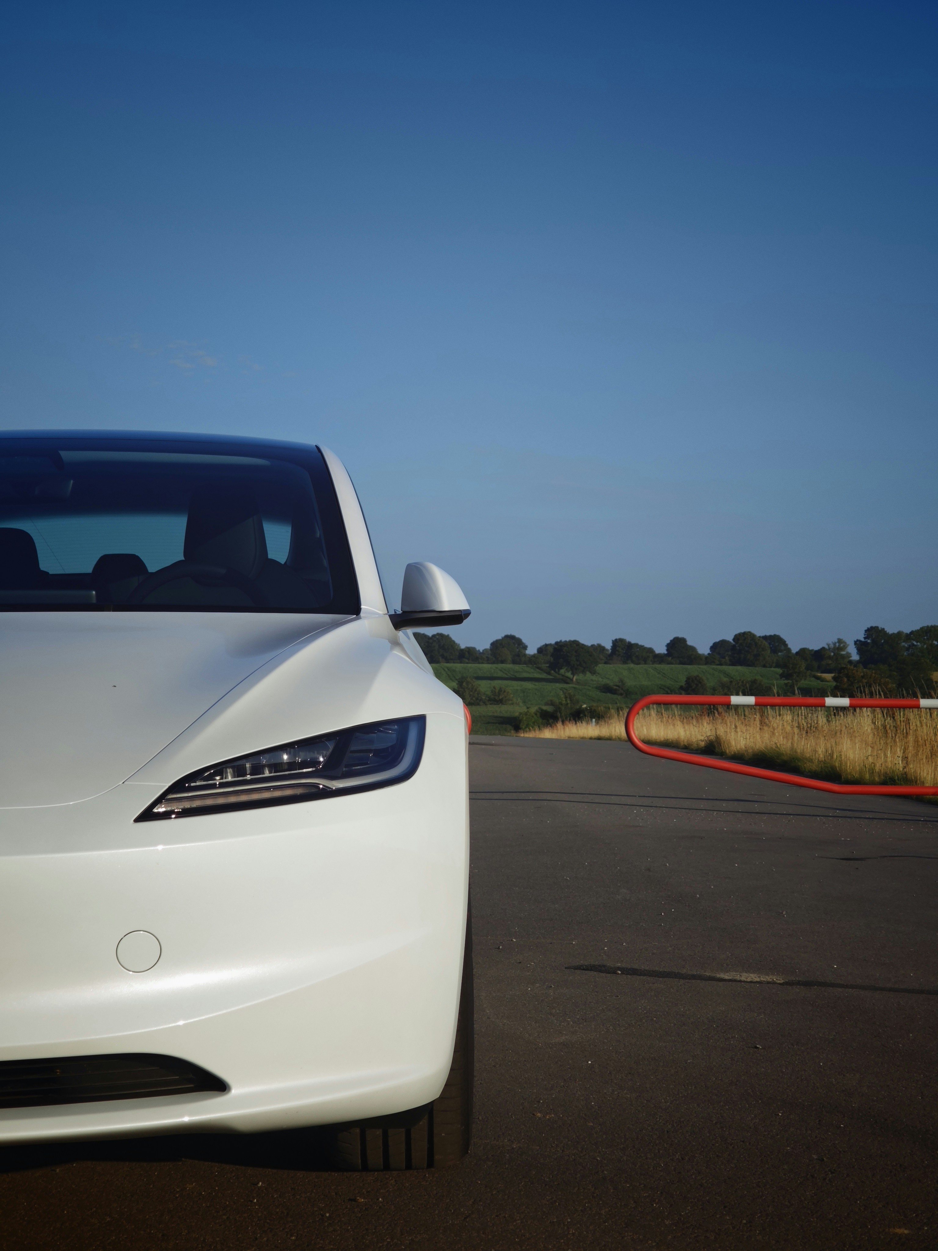 Front-Quarter of a Tesla-esque White Car at an Airstrip