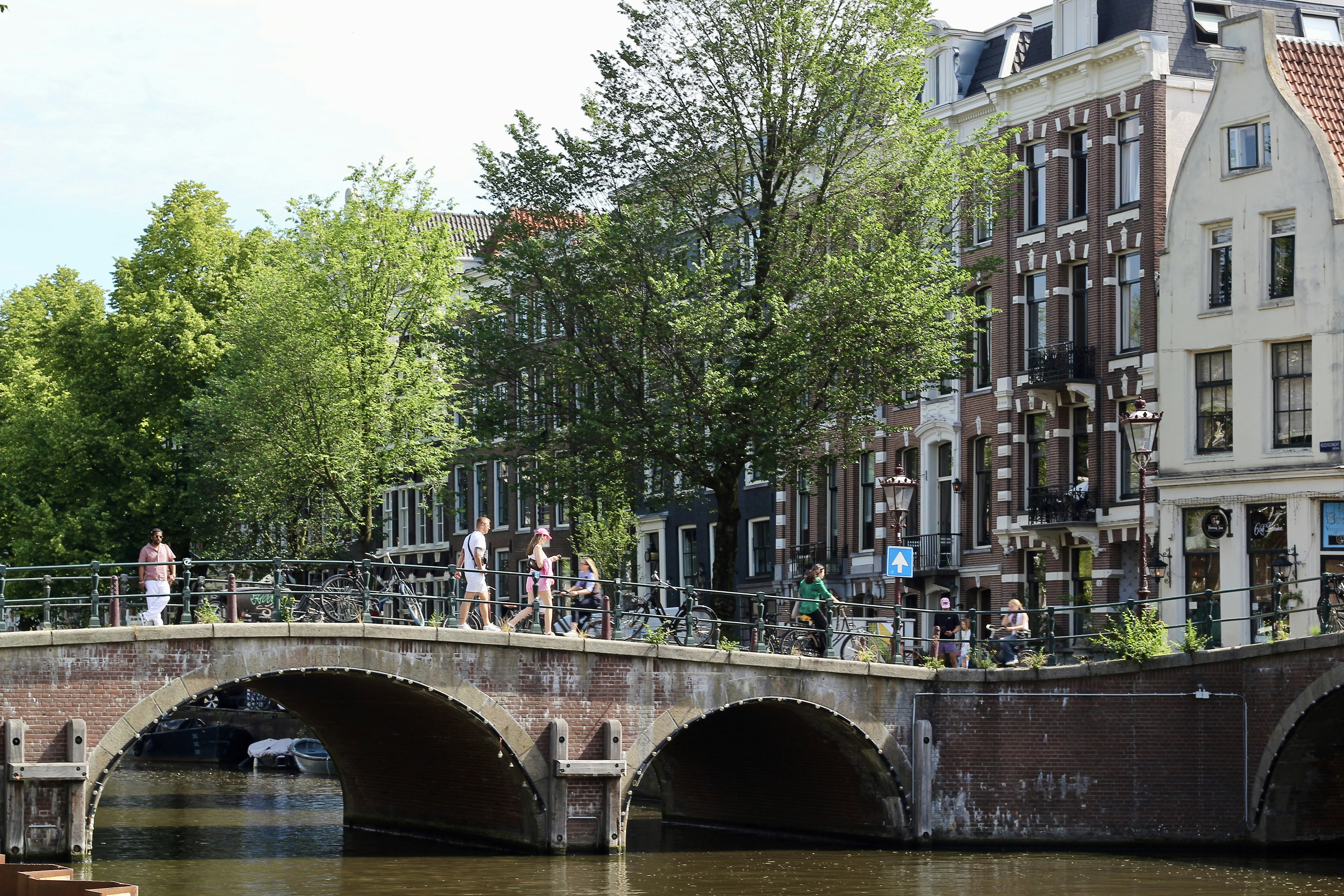 Arched Bridge Over a Calm Canal: Citylife in Bloom