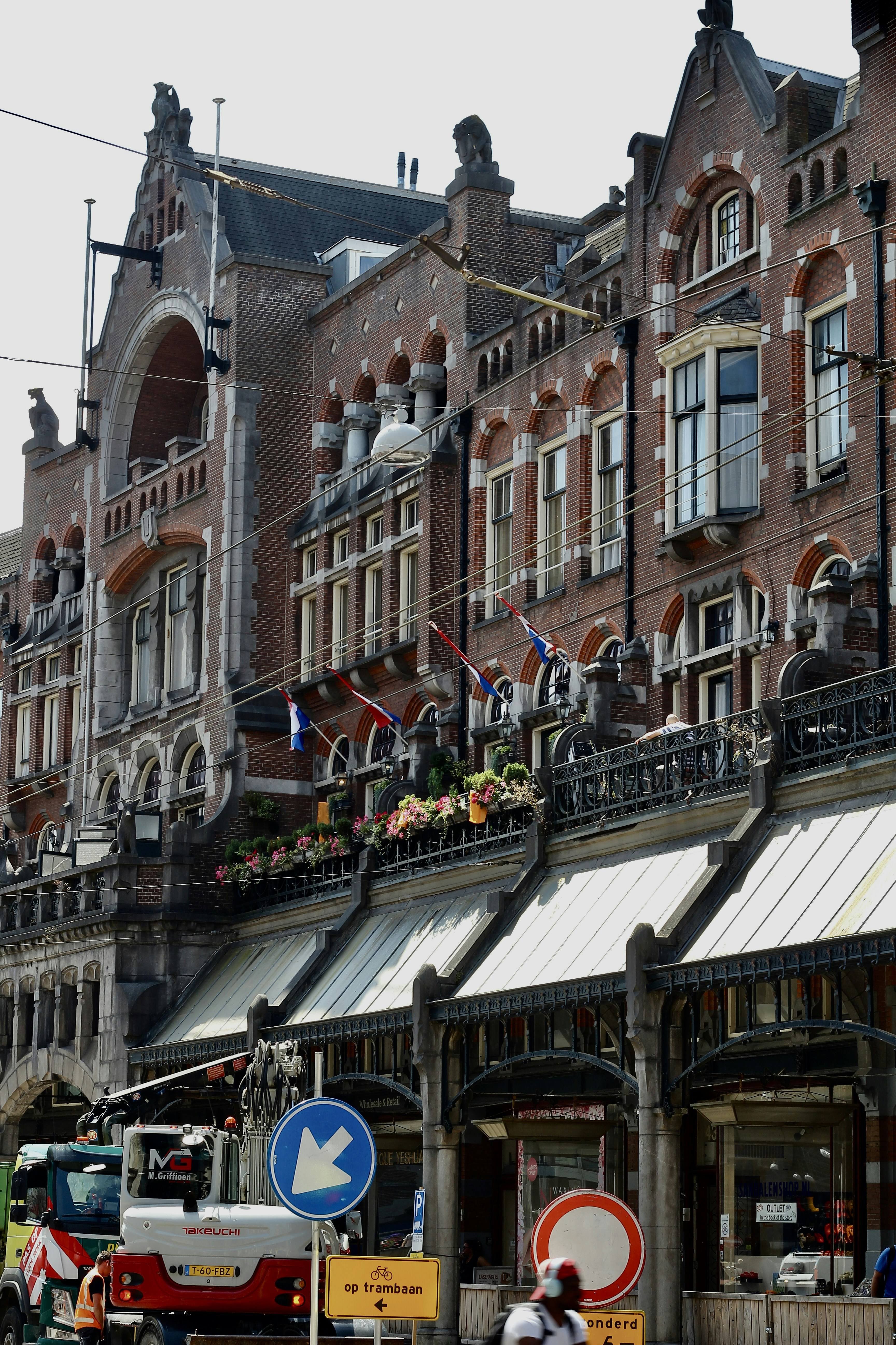 Brick Facades and Flagged Balconies Over a Bustling Dutch Street