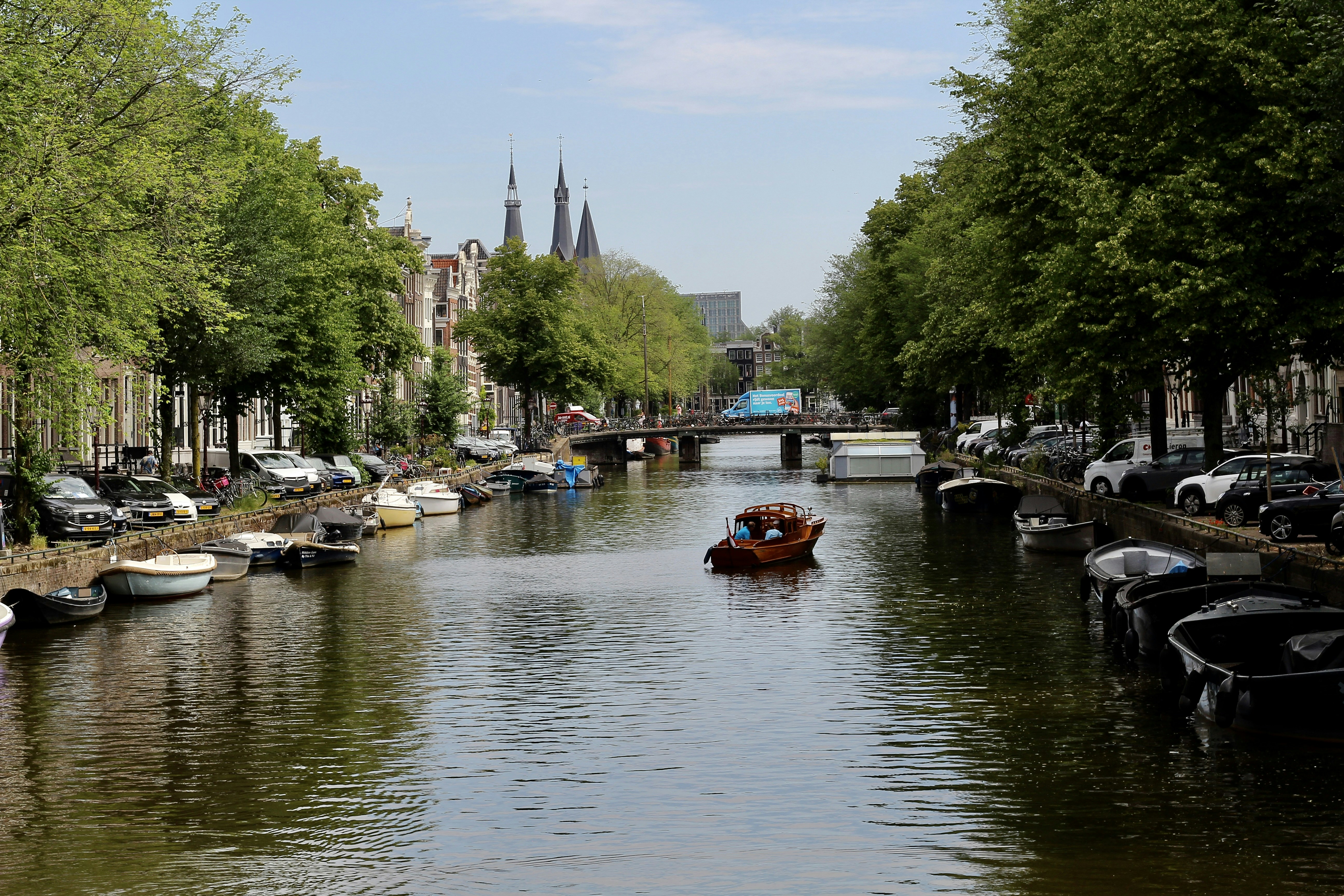 Canal Veil: A Boat Traverses the Flemish-esque Waterway Beneath City Trees