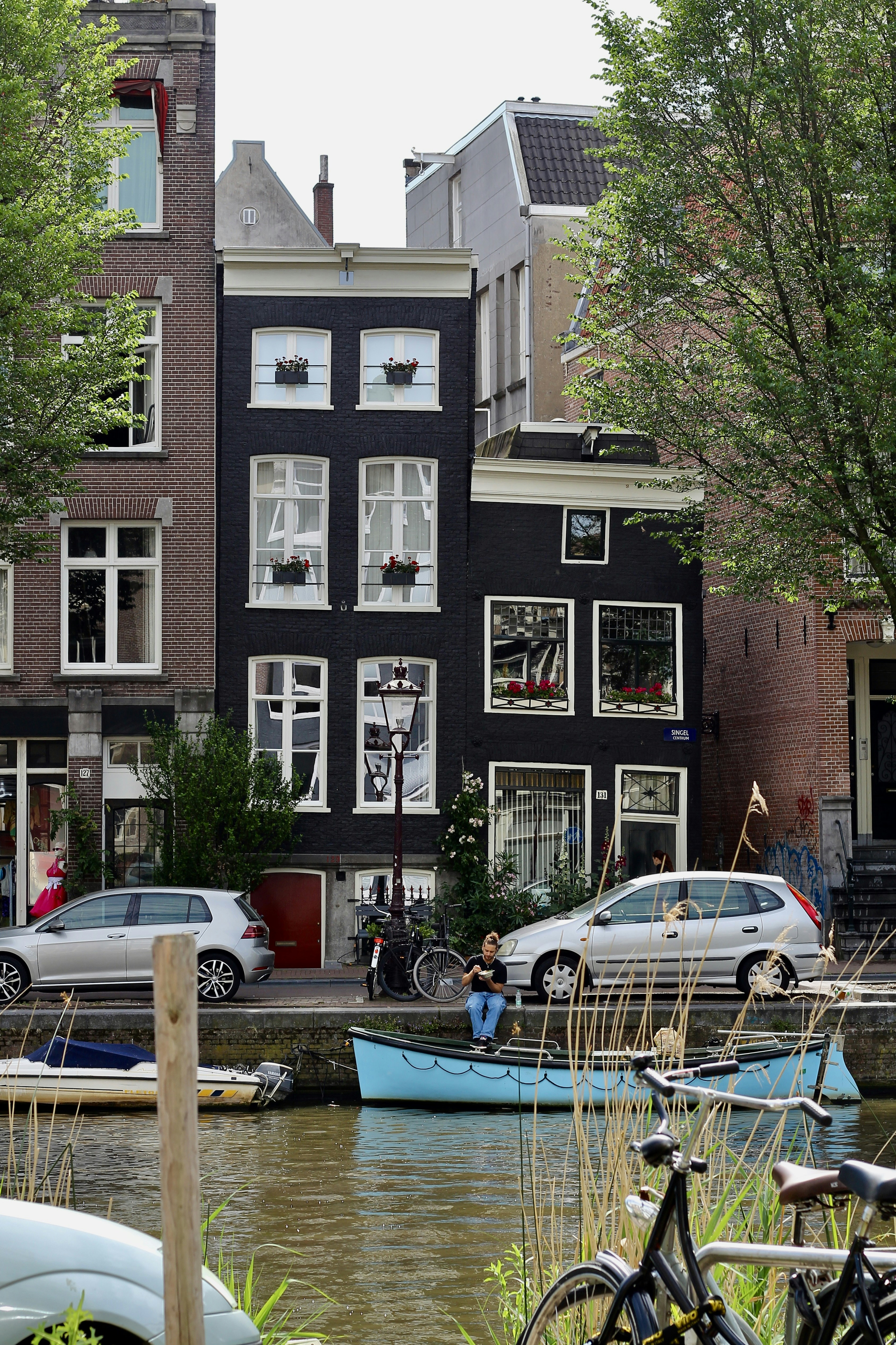 Canalfront Quiet: A Dutch Row of Dark Facades and a Daring Blue Boat