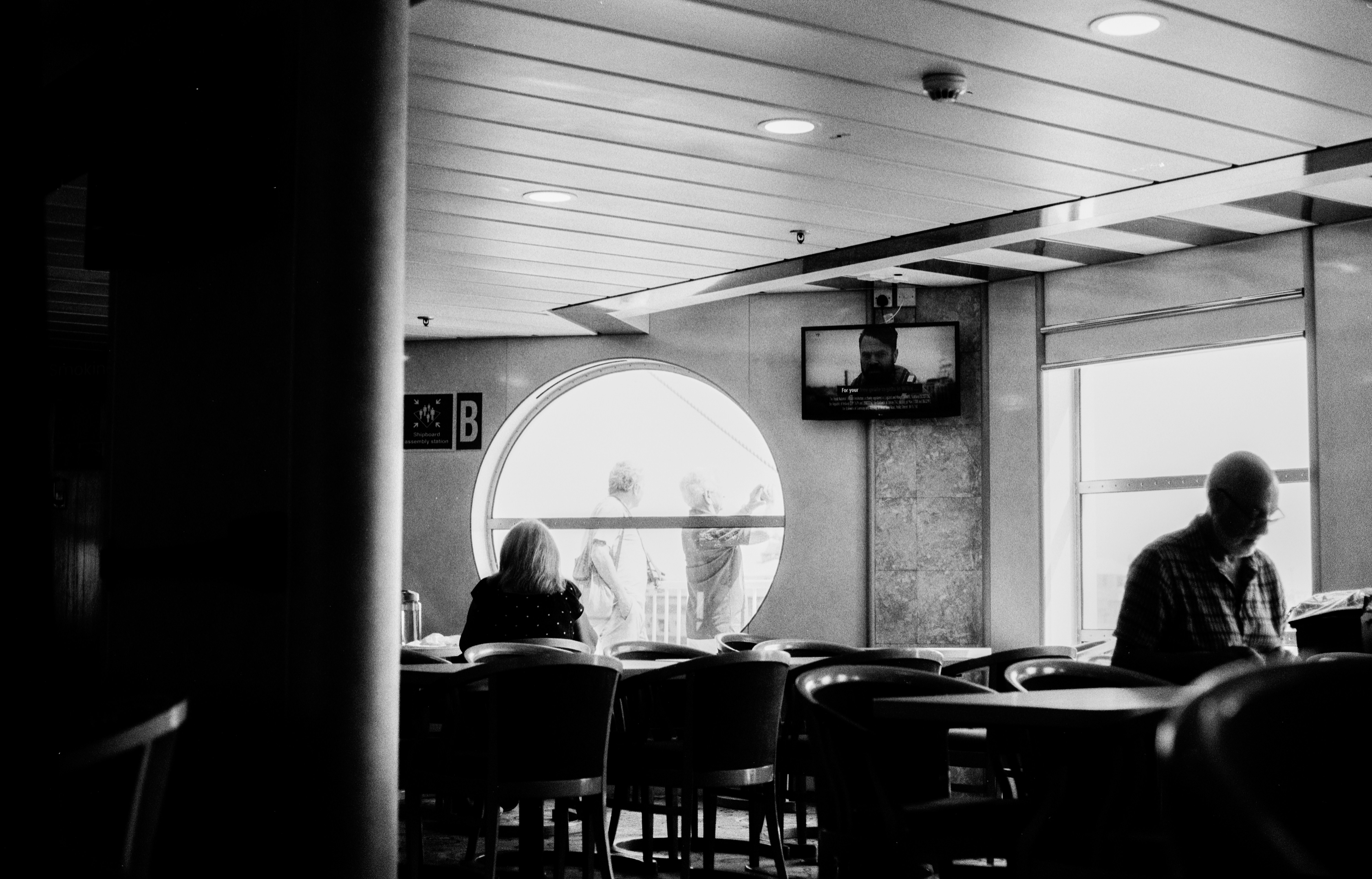 Silhouette at the Circular Window: Quiet Clarity in a Dim Café