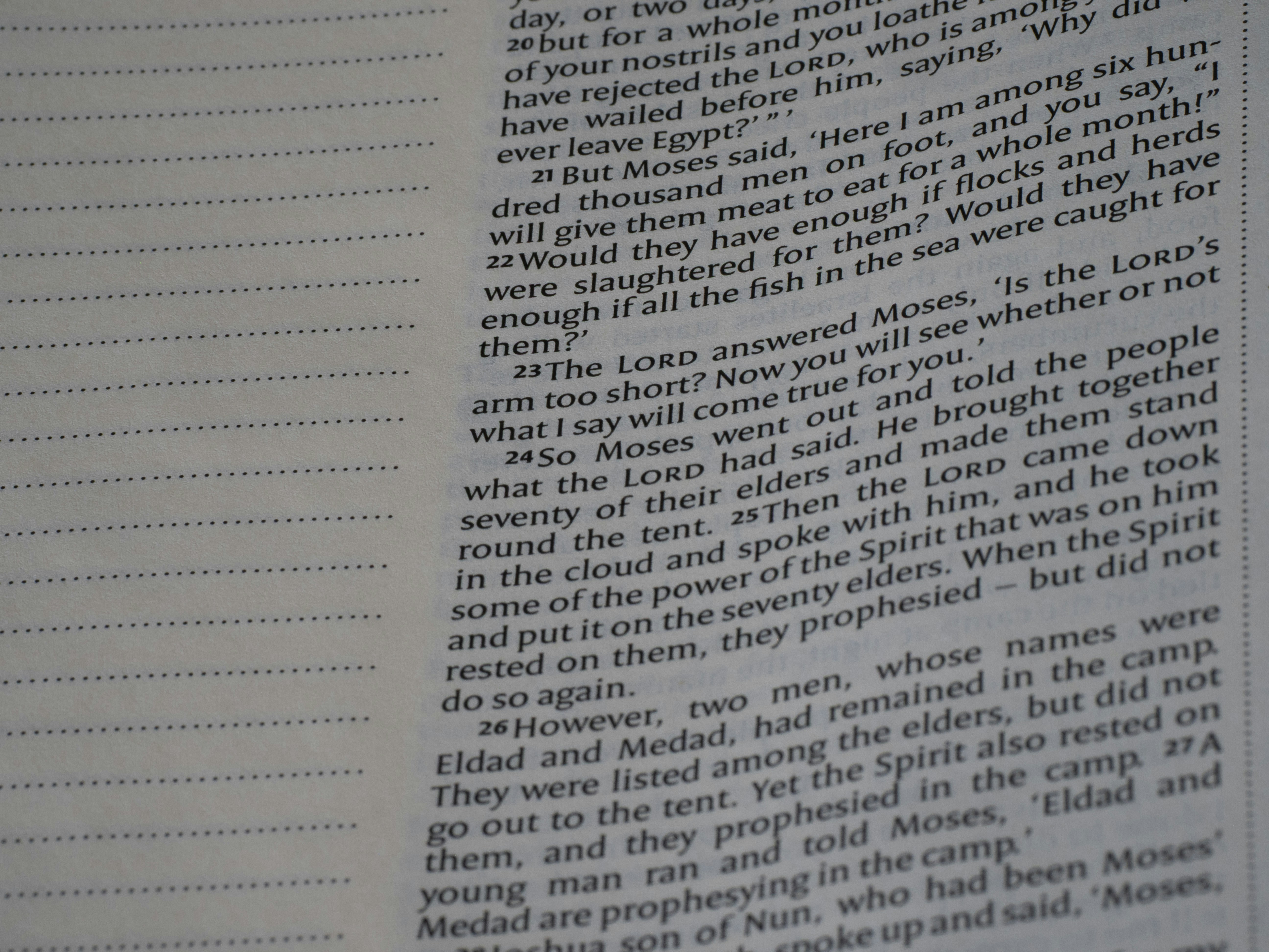 Close-up of a page from a Bible or printed text, showing dense typesetting and verse numbers, highlighting the texture of printed material. This is a photographed page, emphasizing typography and paper texture.