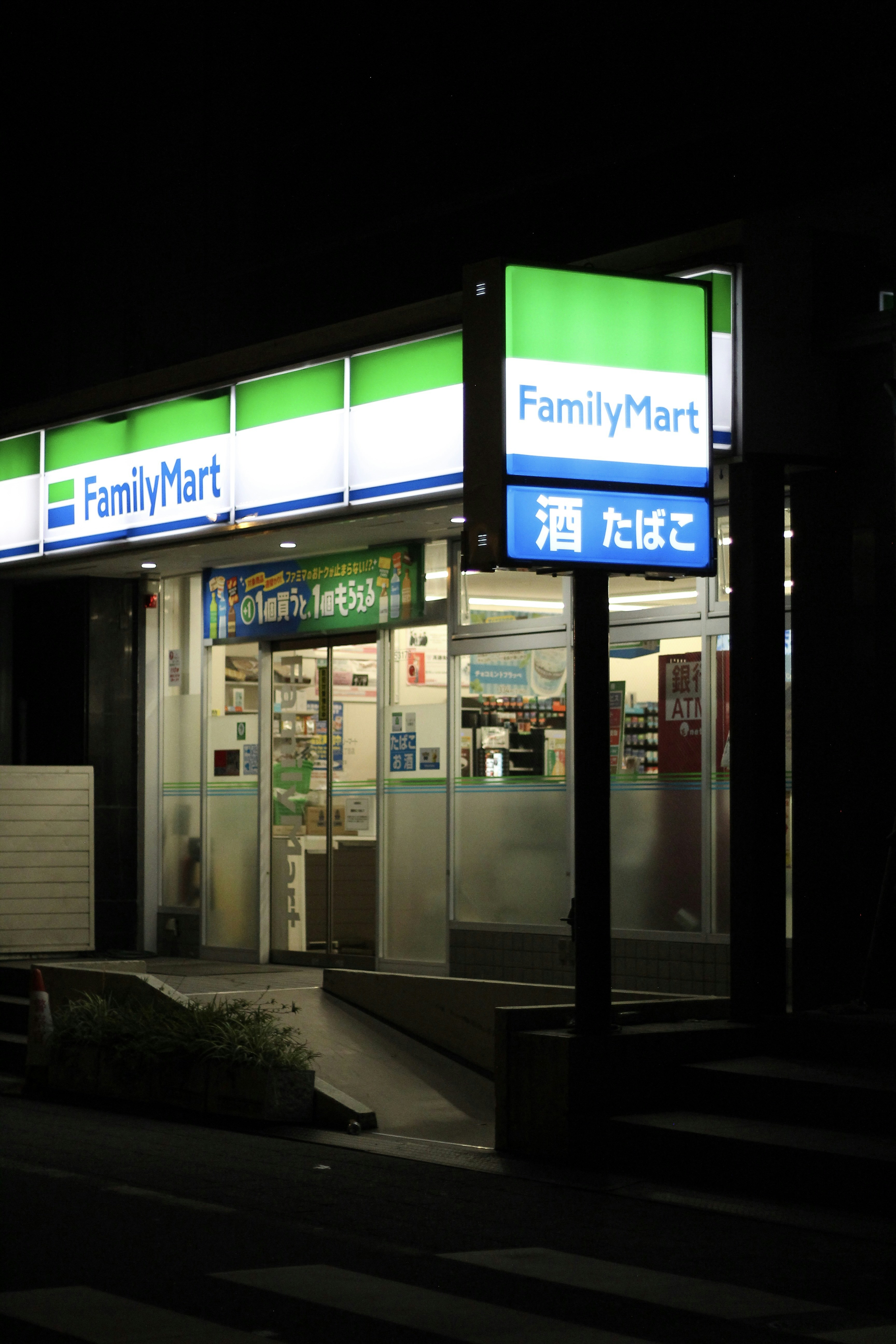 A brightly lit familymart convenience store at night.