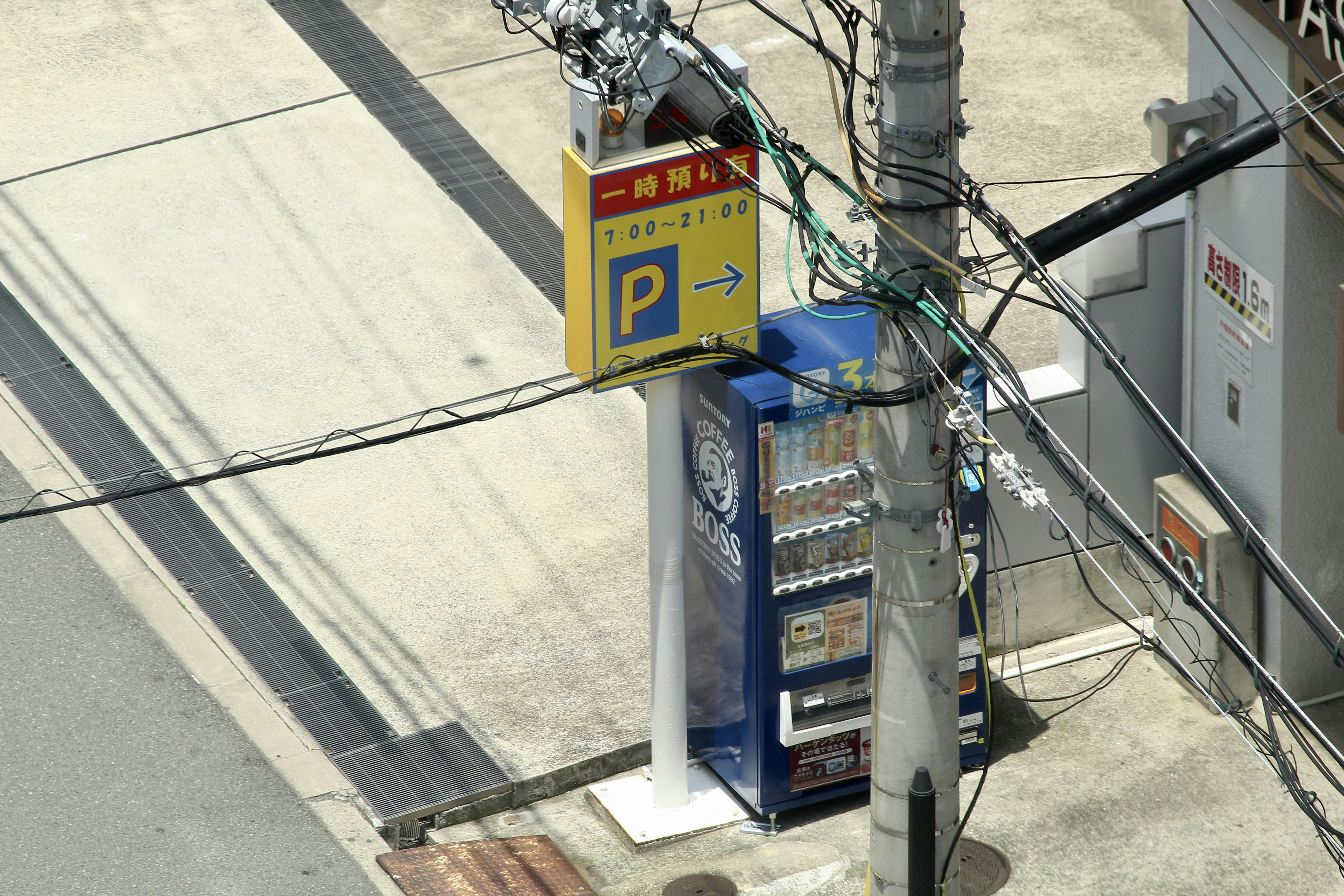 Urban Signpost and Vending Machine Under a Tangle of Wires