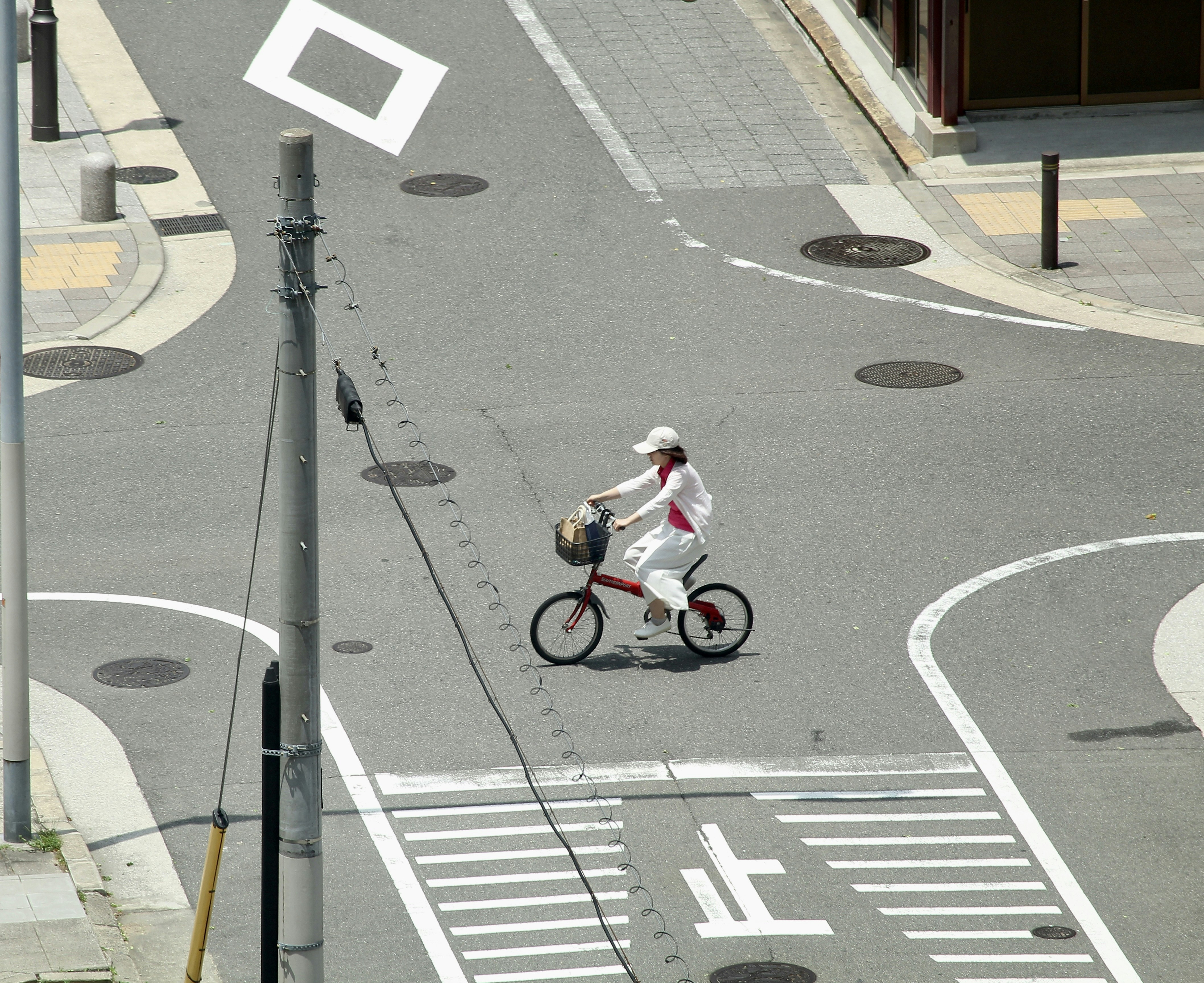 A person rides a bicycle across a street intersection.