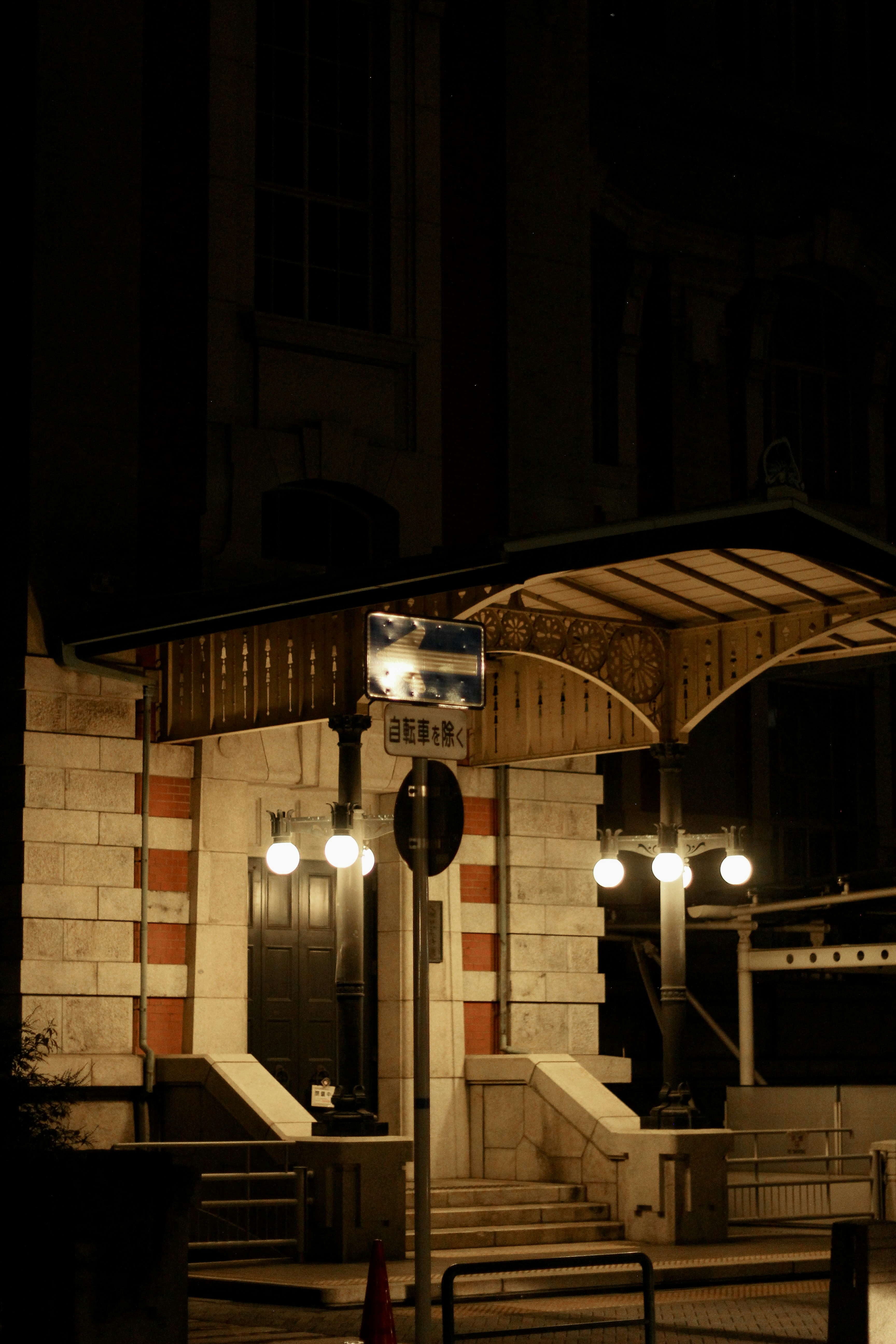 Night Entrance: Warm Lamps Guiding Through the Stone Facade