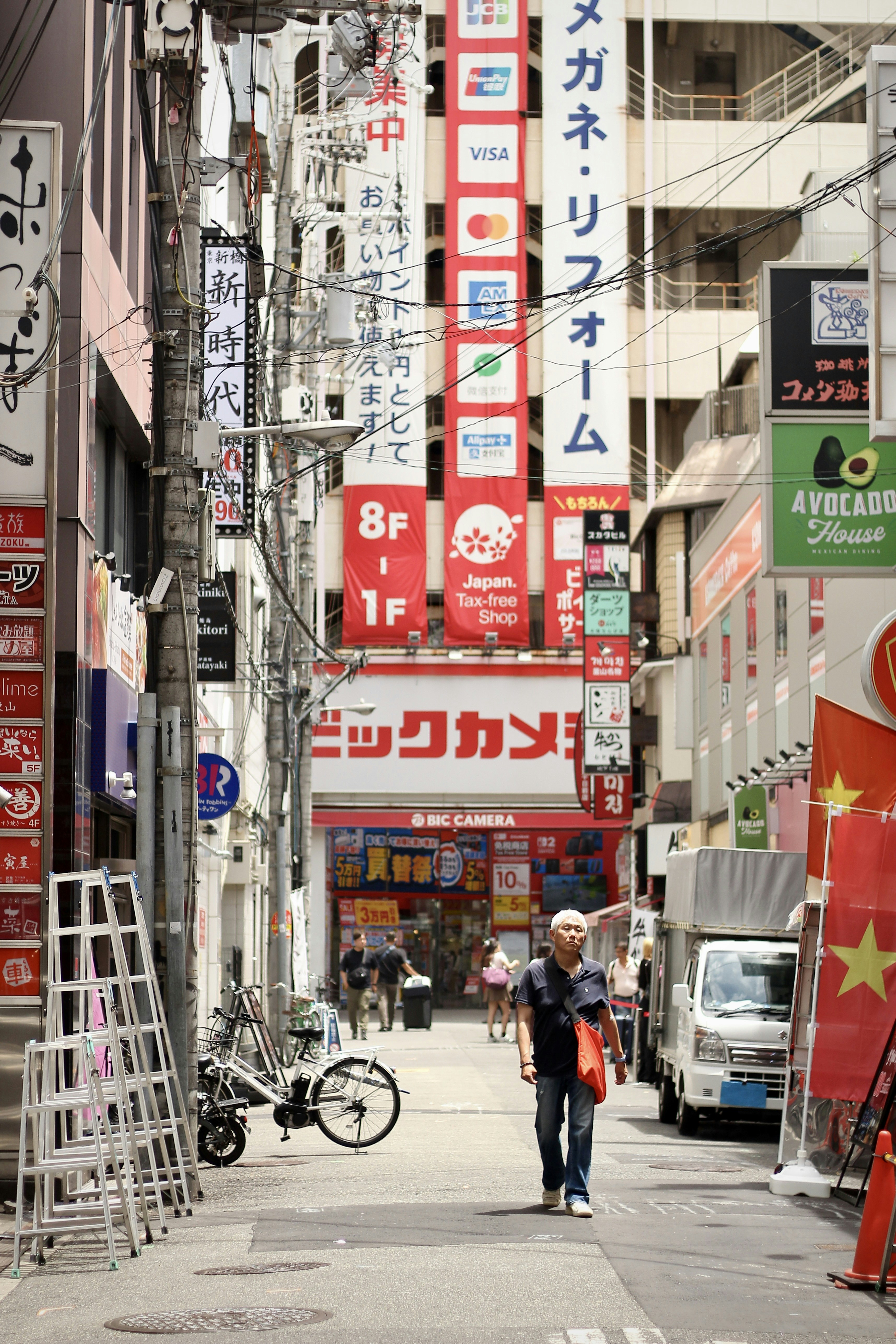 City Alley Portrait: A Bald-Headed Shopper Steps Through Neon Pulse