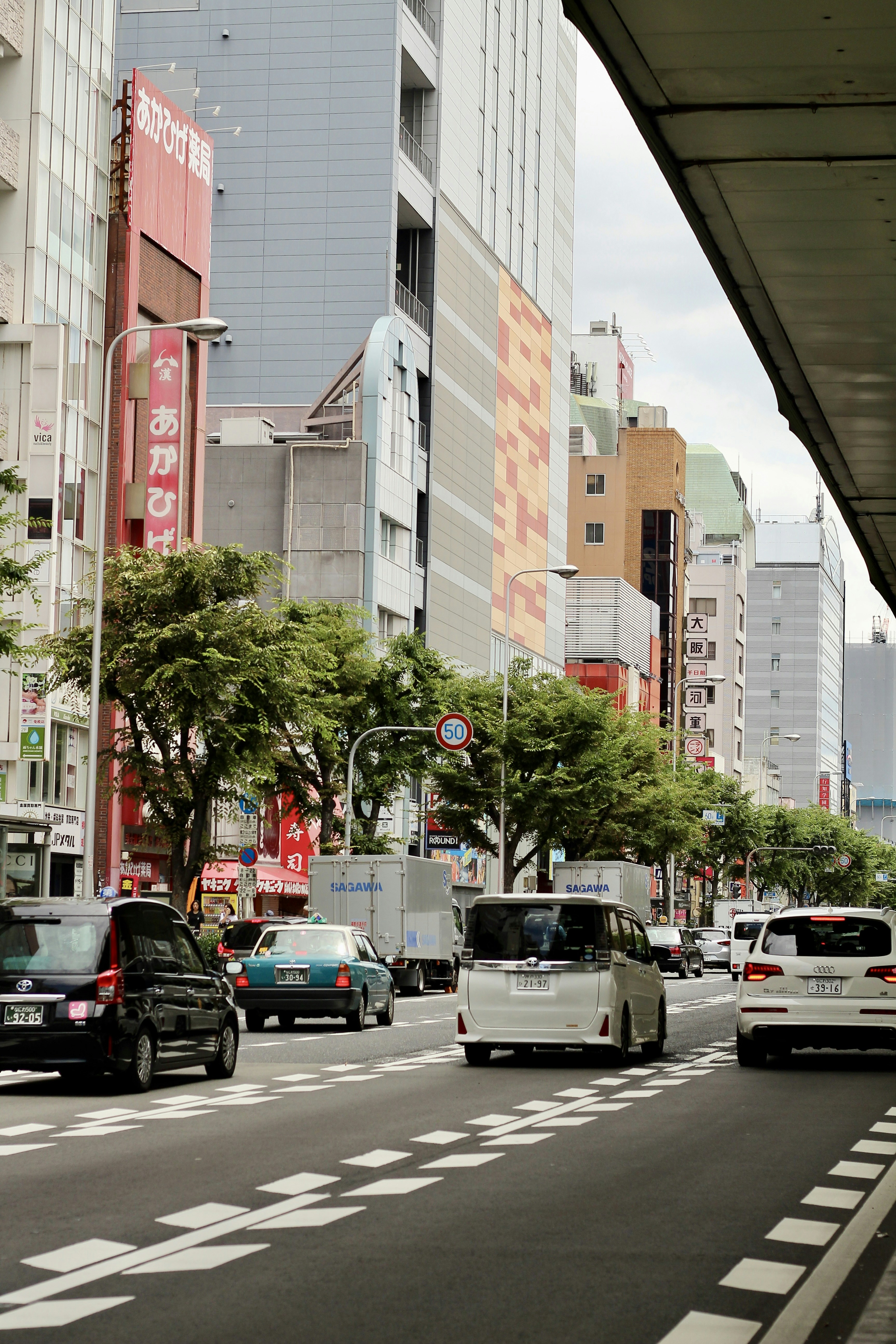 Urban Flow: Cars, Signs, and Skyscrapers on a Lively City Street