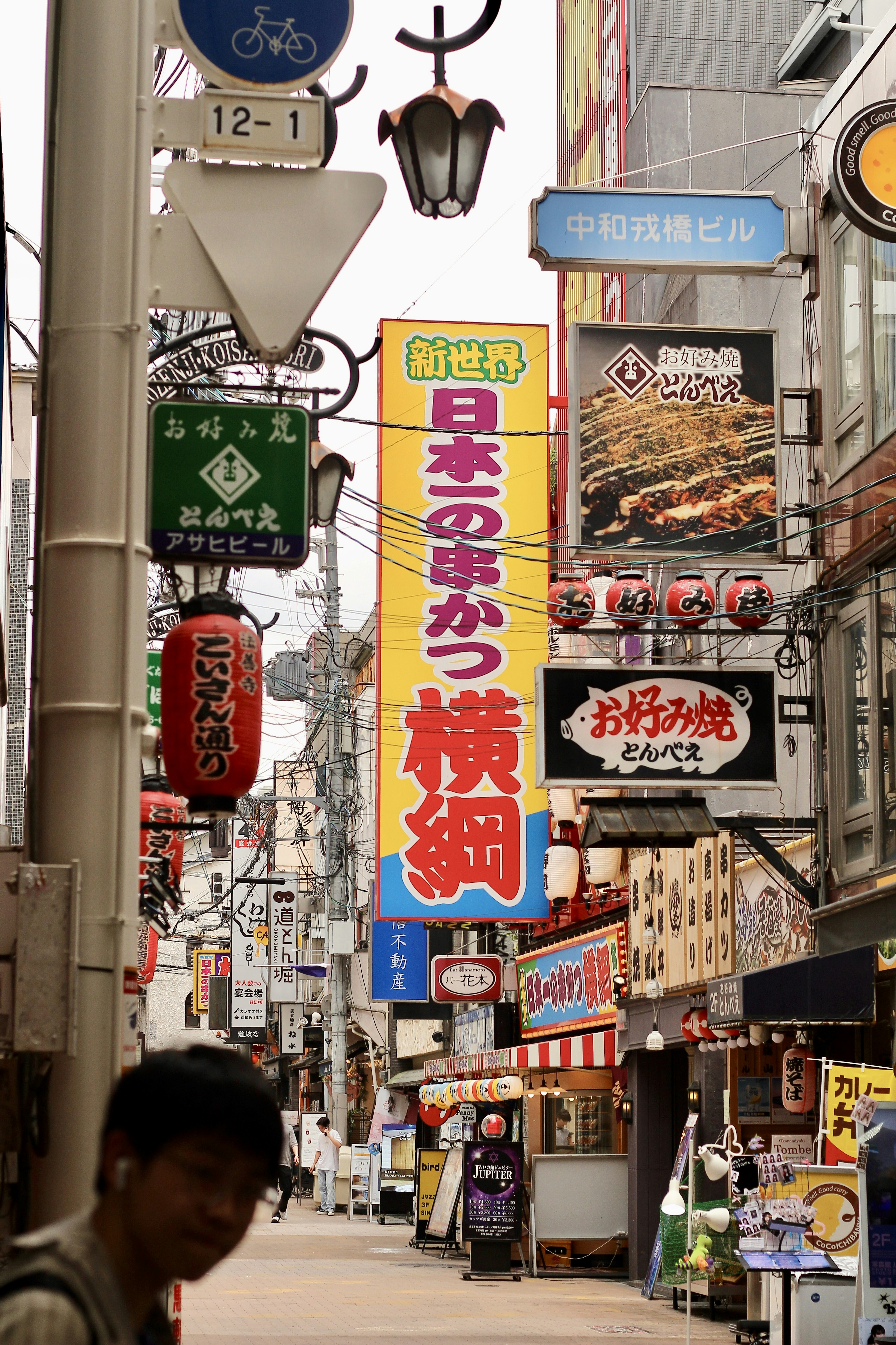 Neon Corridor: Vertical Japanese Signage Looms Over Bustling Street