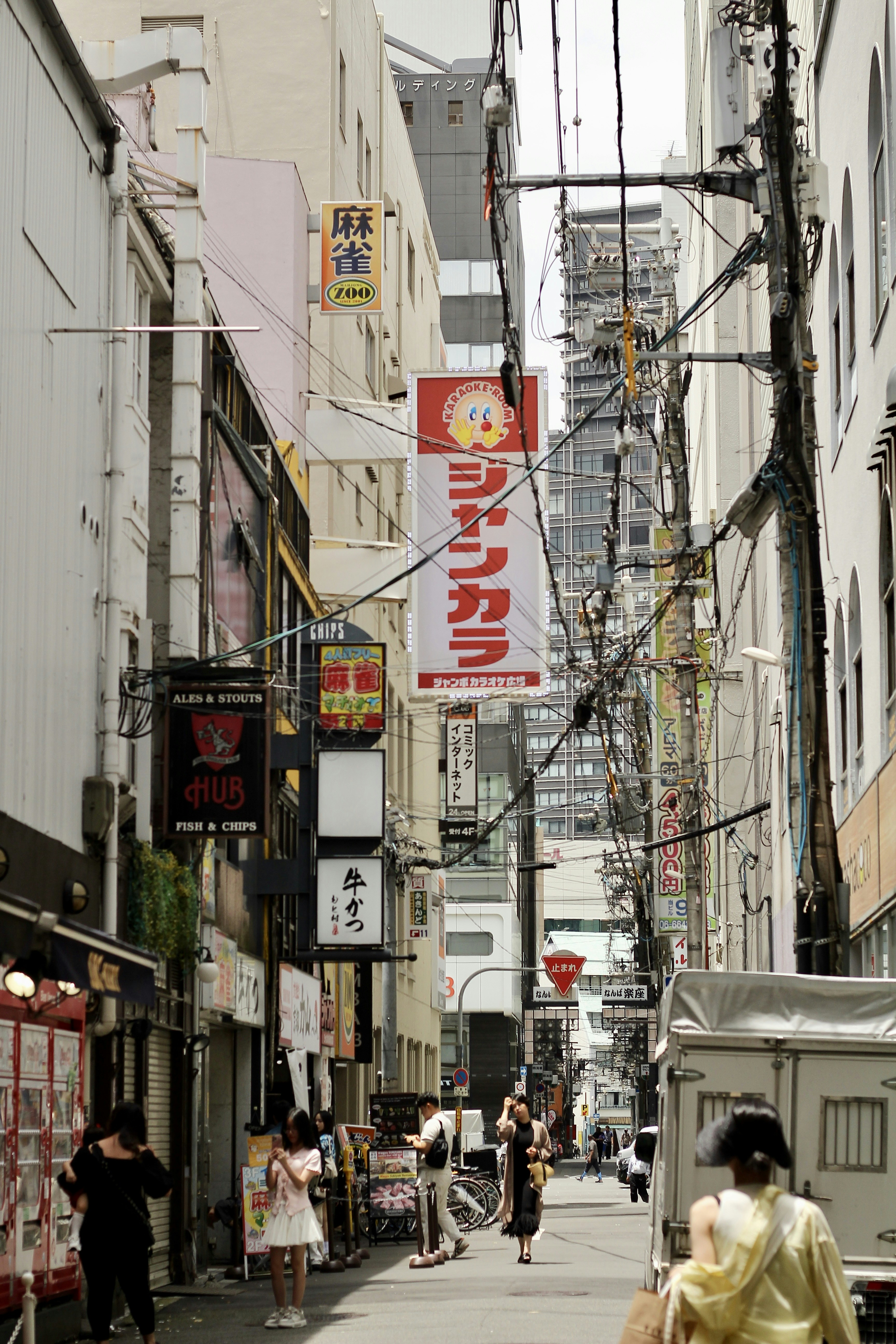 Neon Alleyways: Signs Tower Over a Bustling Osaka Lane