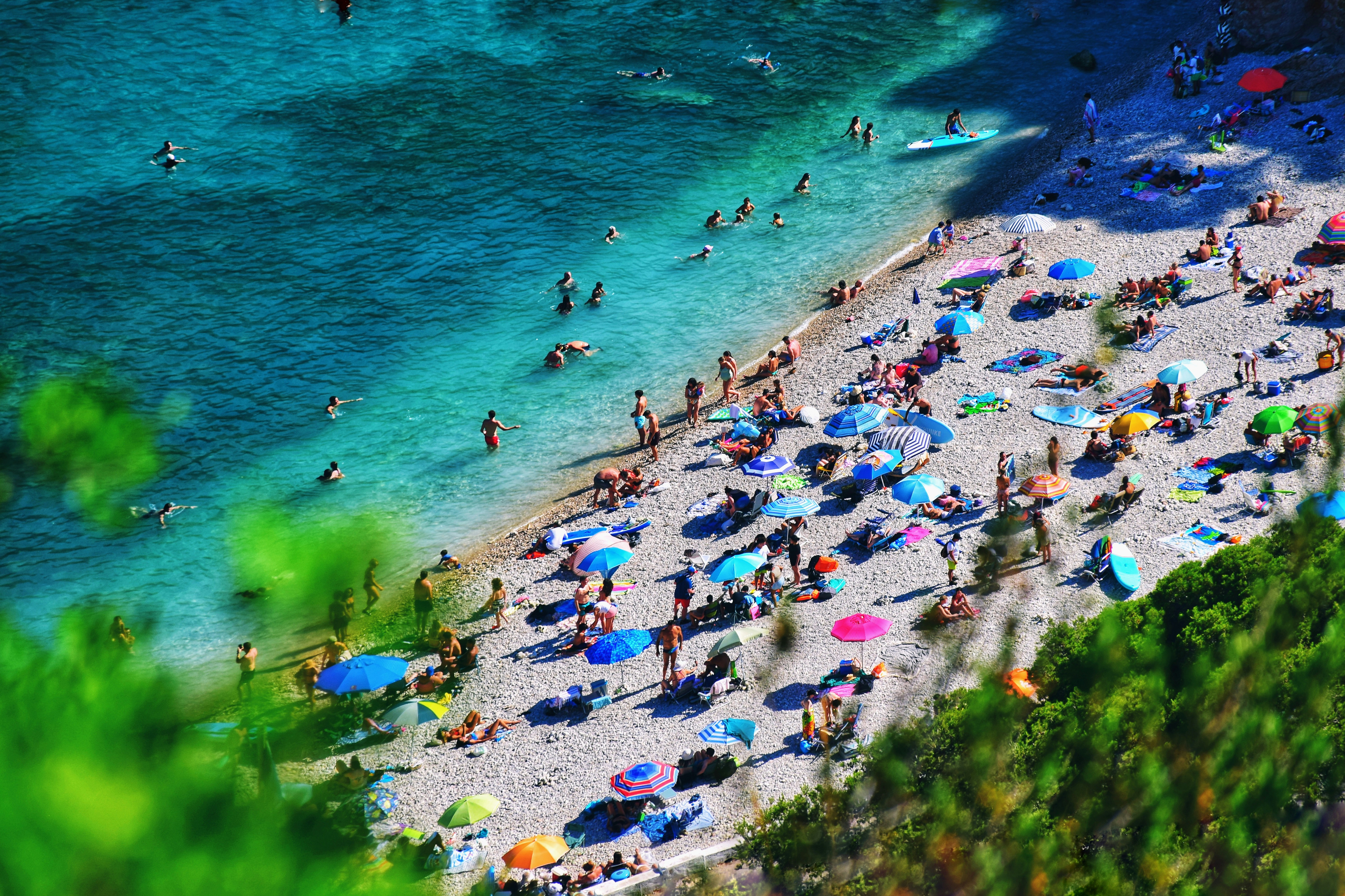 Sunlit Strip: A Bustling Beach Scene Fanning Out from the Clear Blue Sea