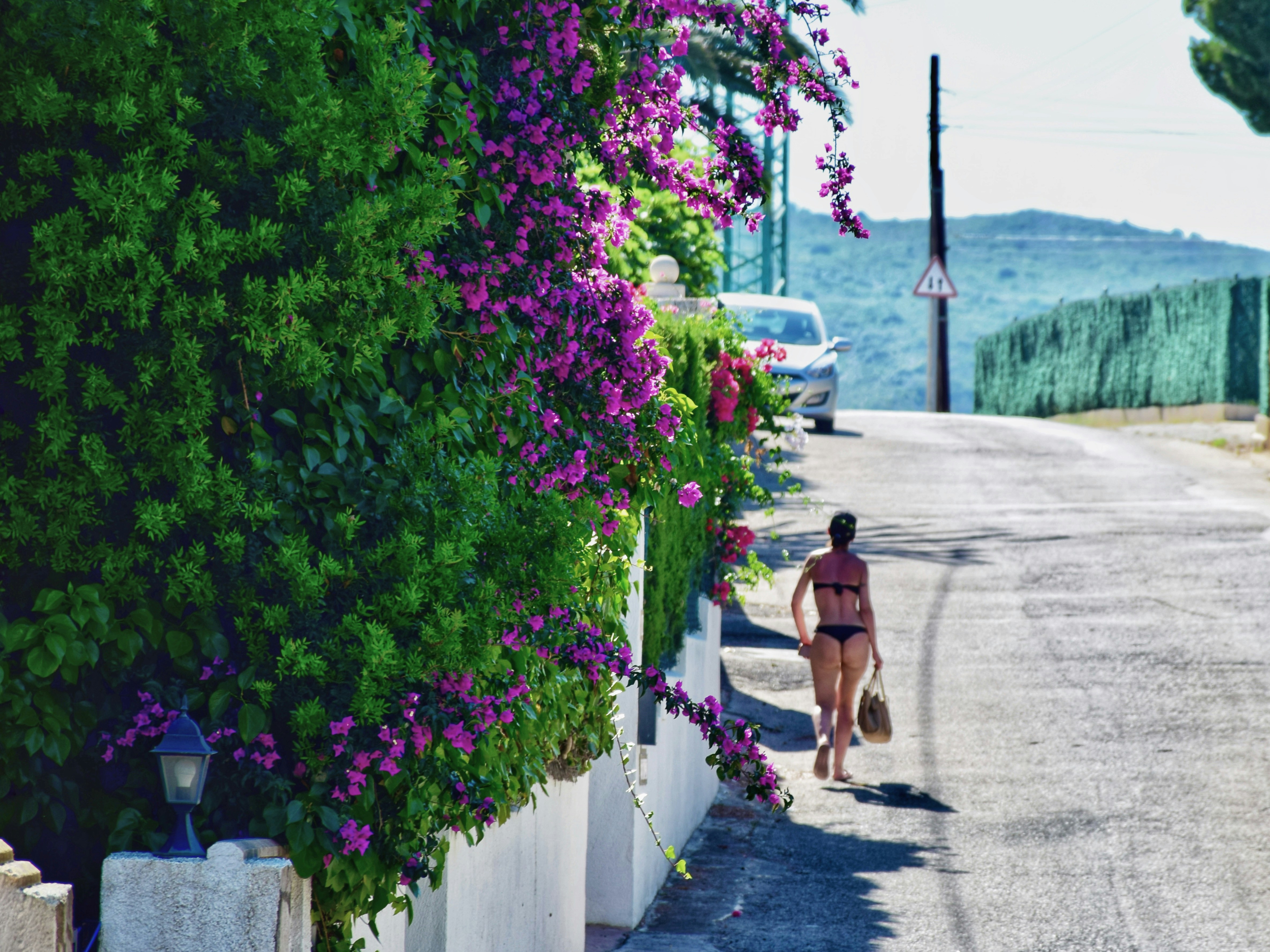 Sunlit Path: A Bikini-Clad Stride Along a Mediterranean Lane