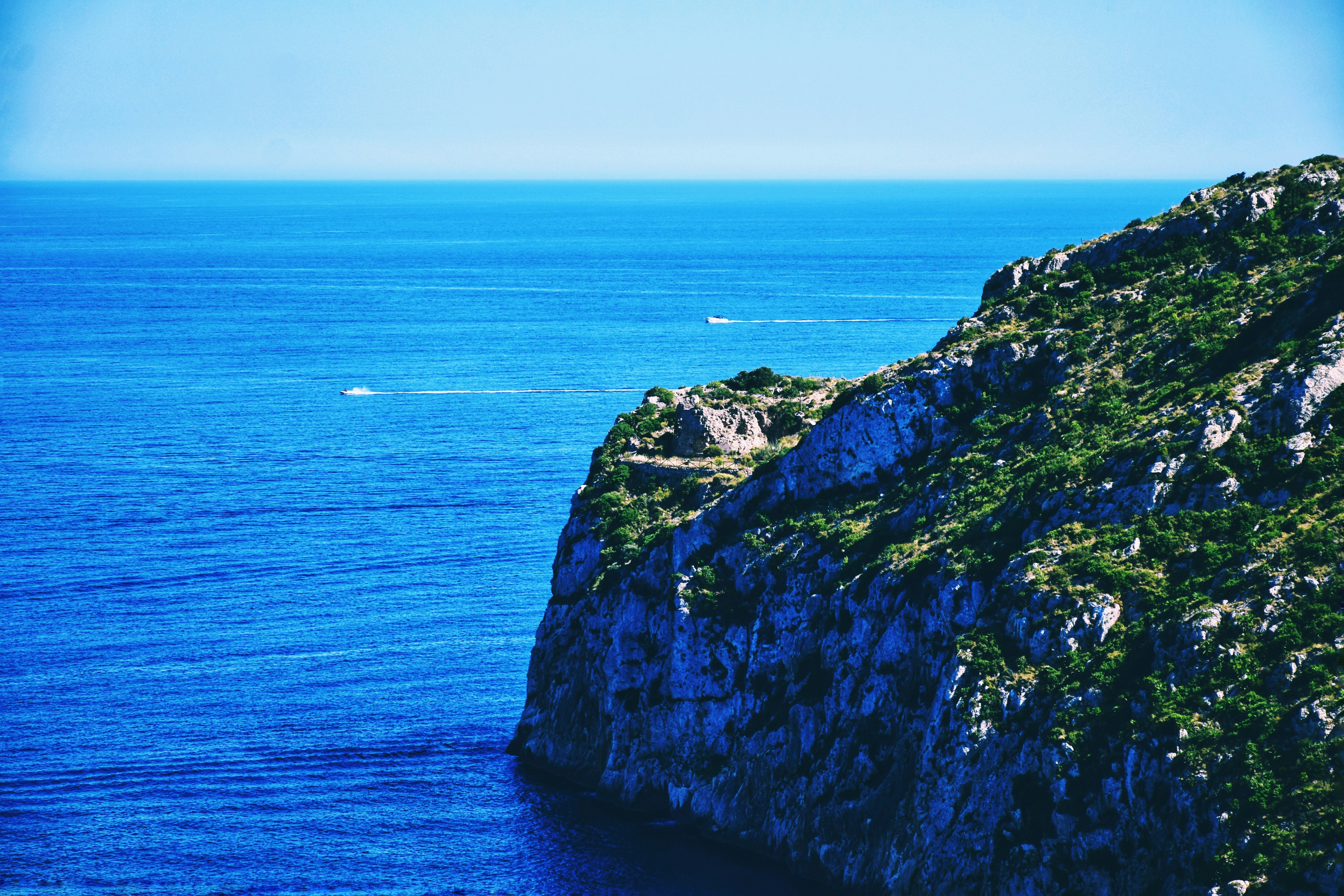 Cliffside Blue: A Luminous Sea Meeting Rugged Rocks