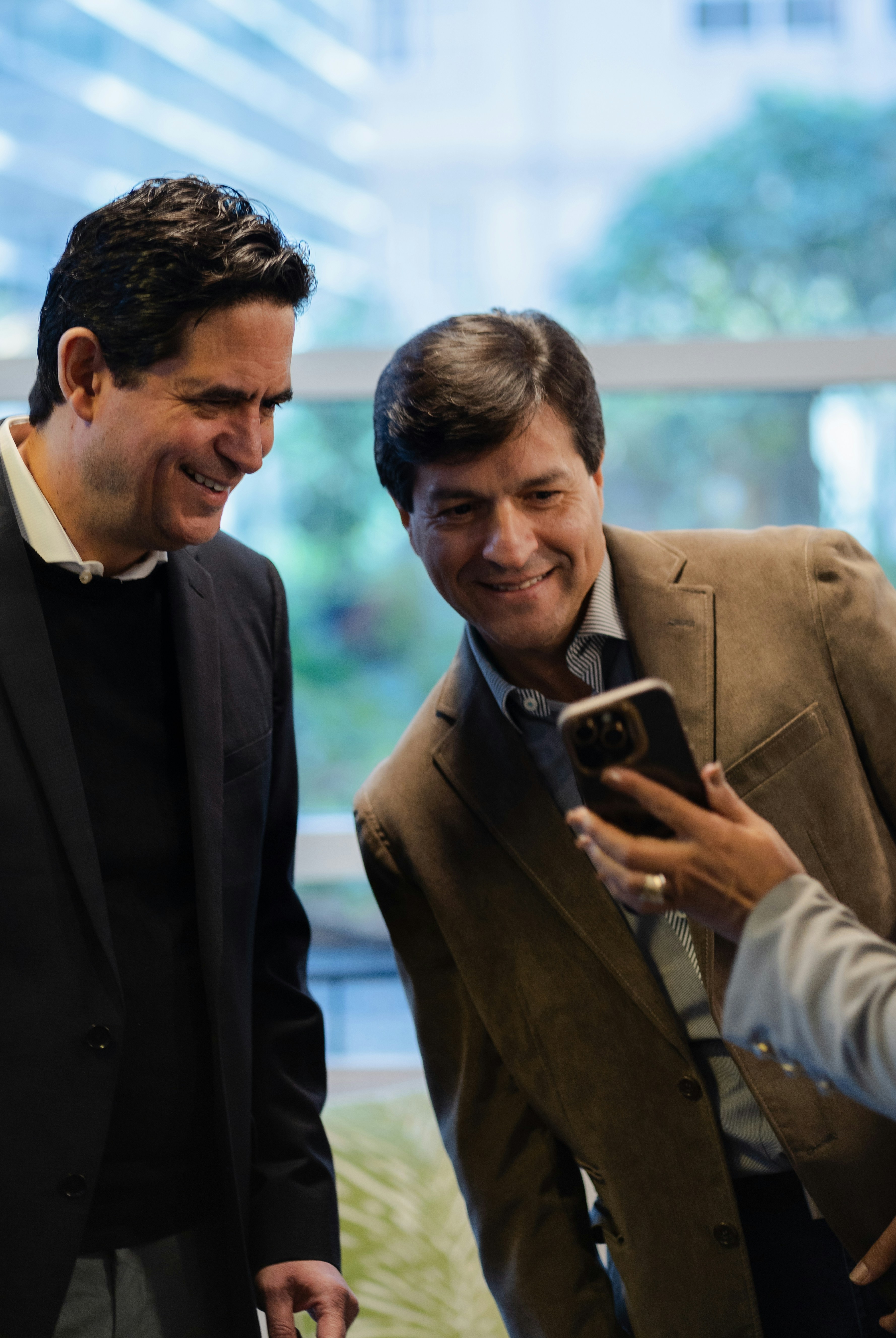 Two Colleagues Laugh as a Phone Reveal Sparks a Rooftop Moment