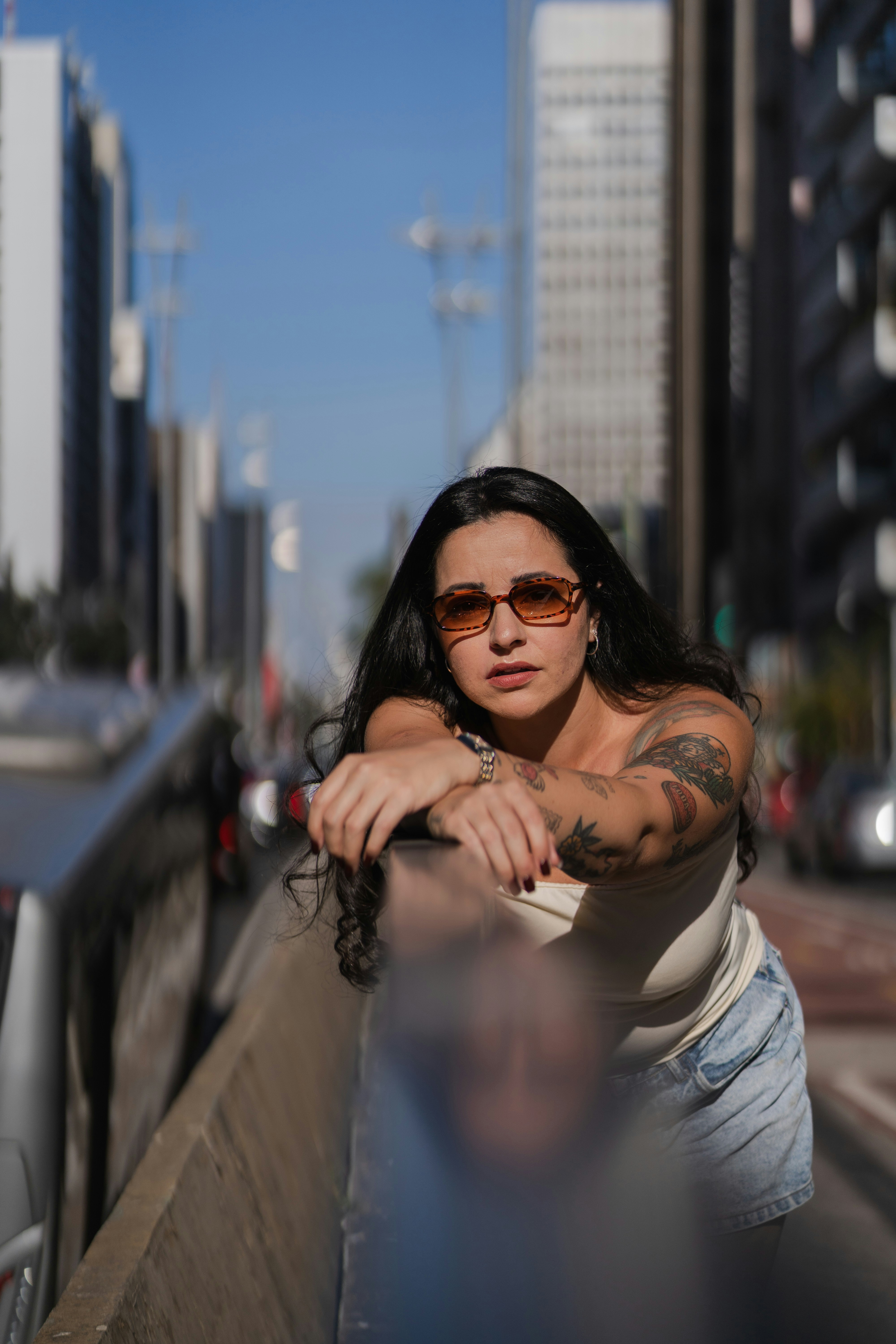 Urban Glance: A Woman Leaning Over a Rail in the City Light