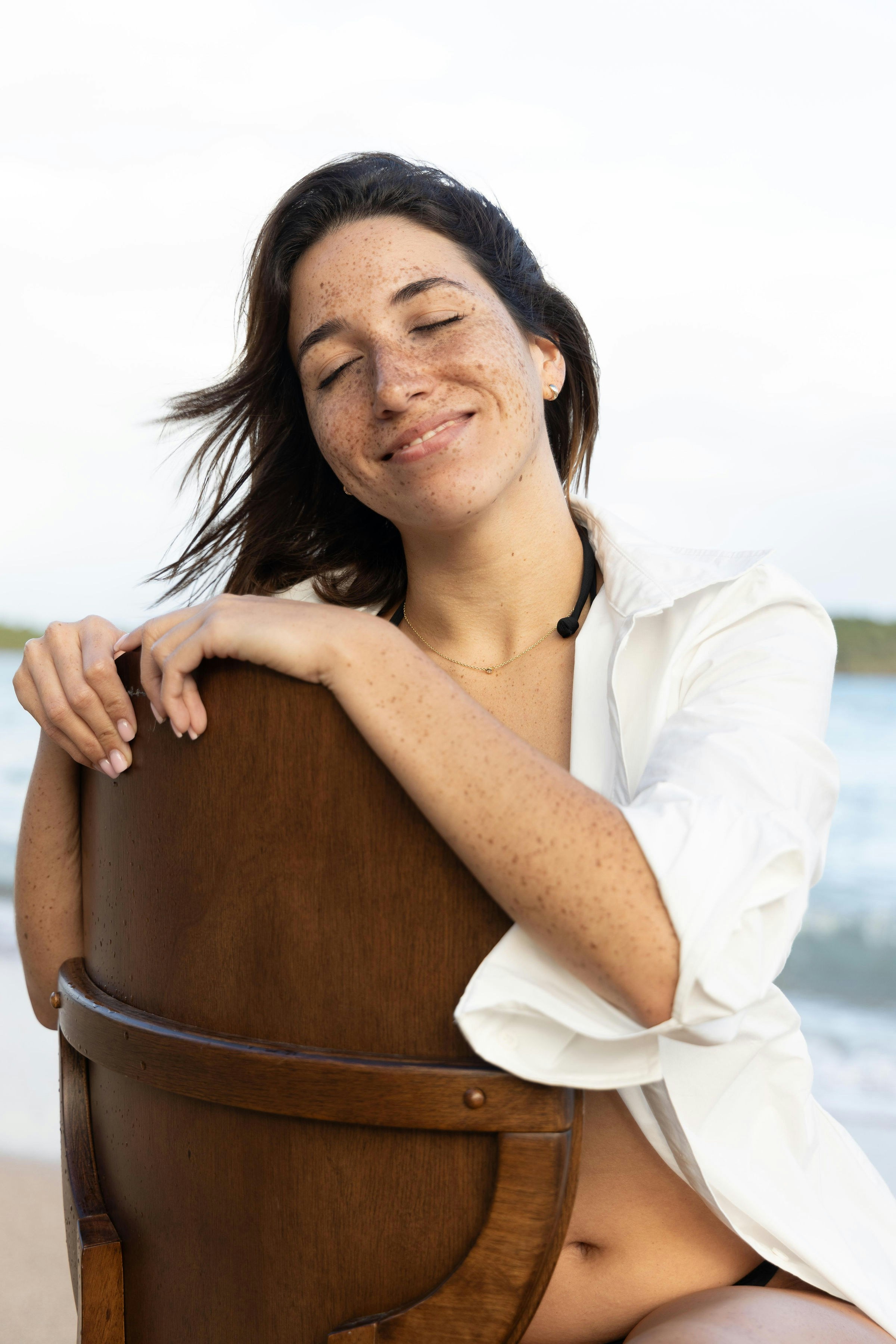 Sunlit Freckled Smile Behind the Wooden Backrest
