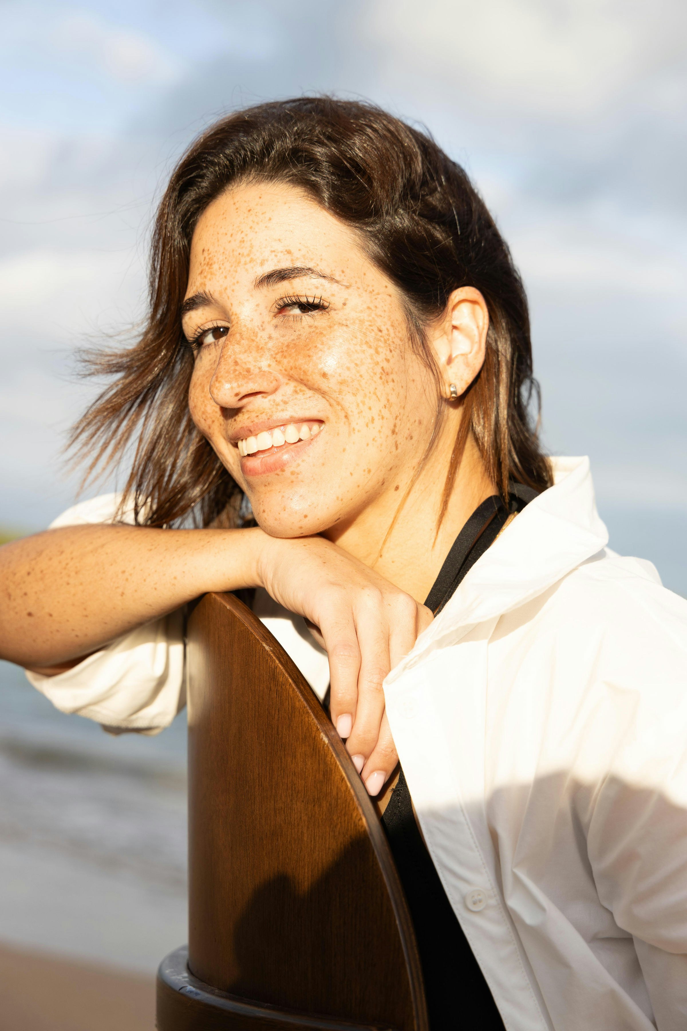 Sunlit Smile by the Shore: Portrait with a Surfboard Silhouette