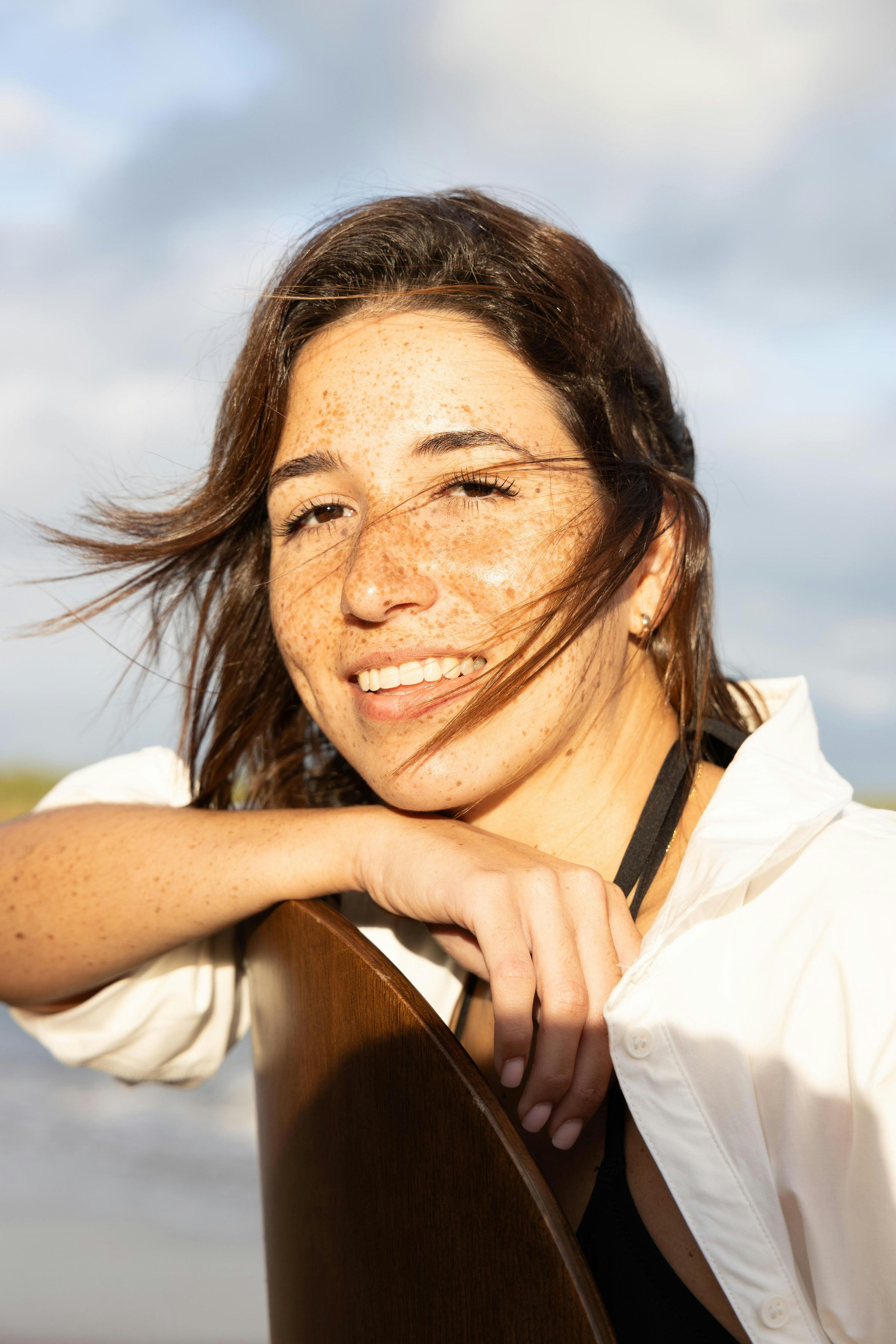 Sunlit confidante: a windswept portrait with a windswept smile