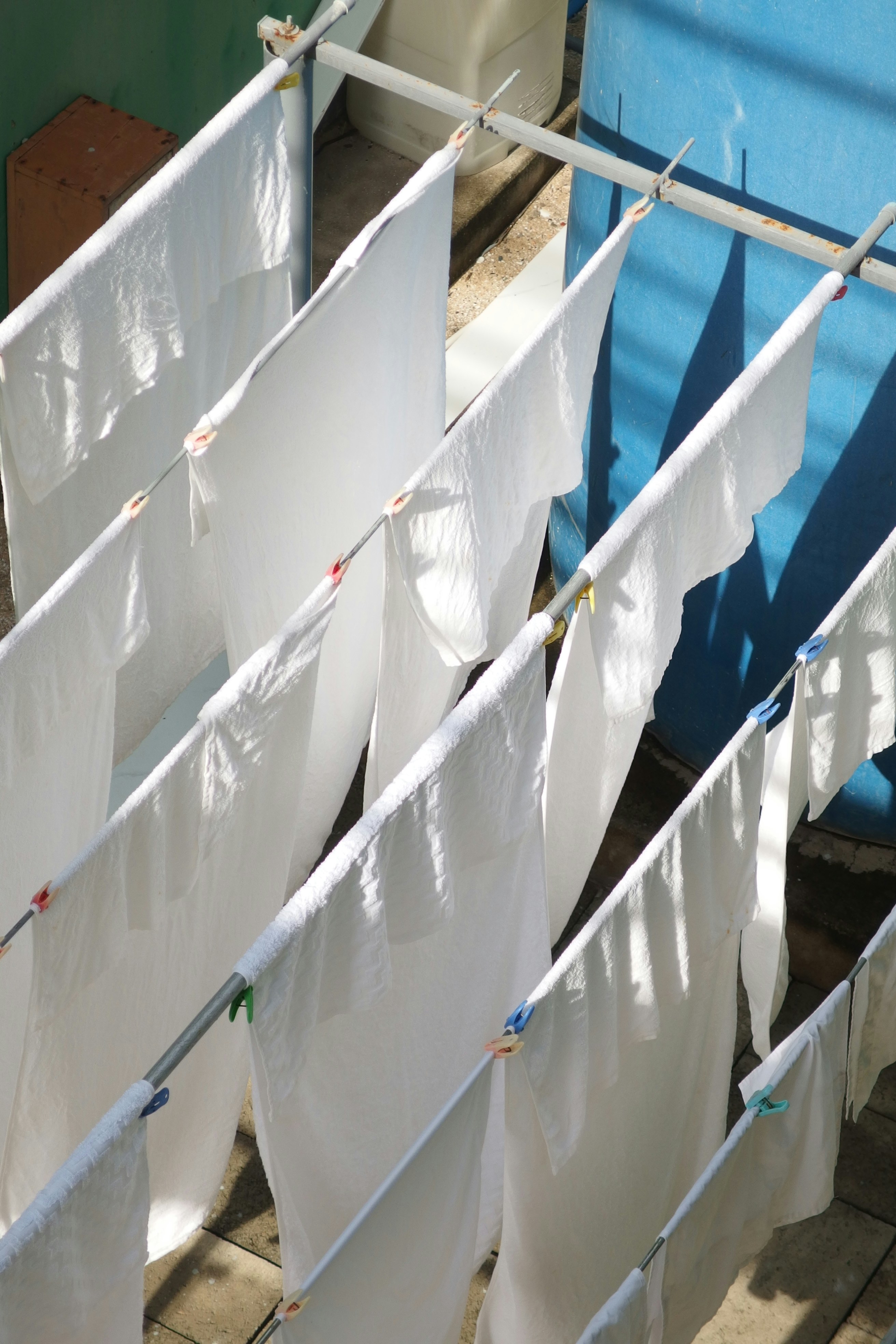 Sunlit Laundry Lines: White Sheets Dancing on a Rooftop Breeze