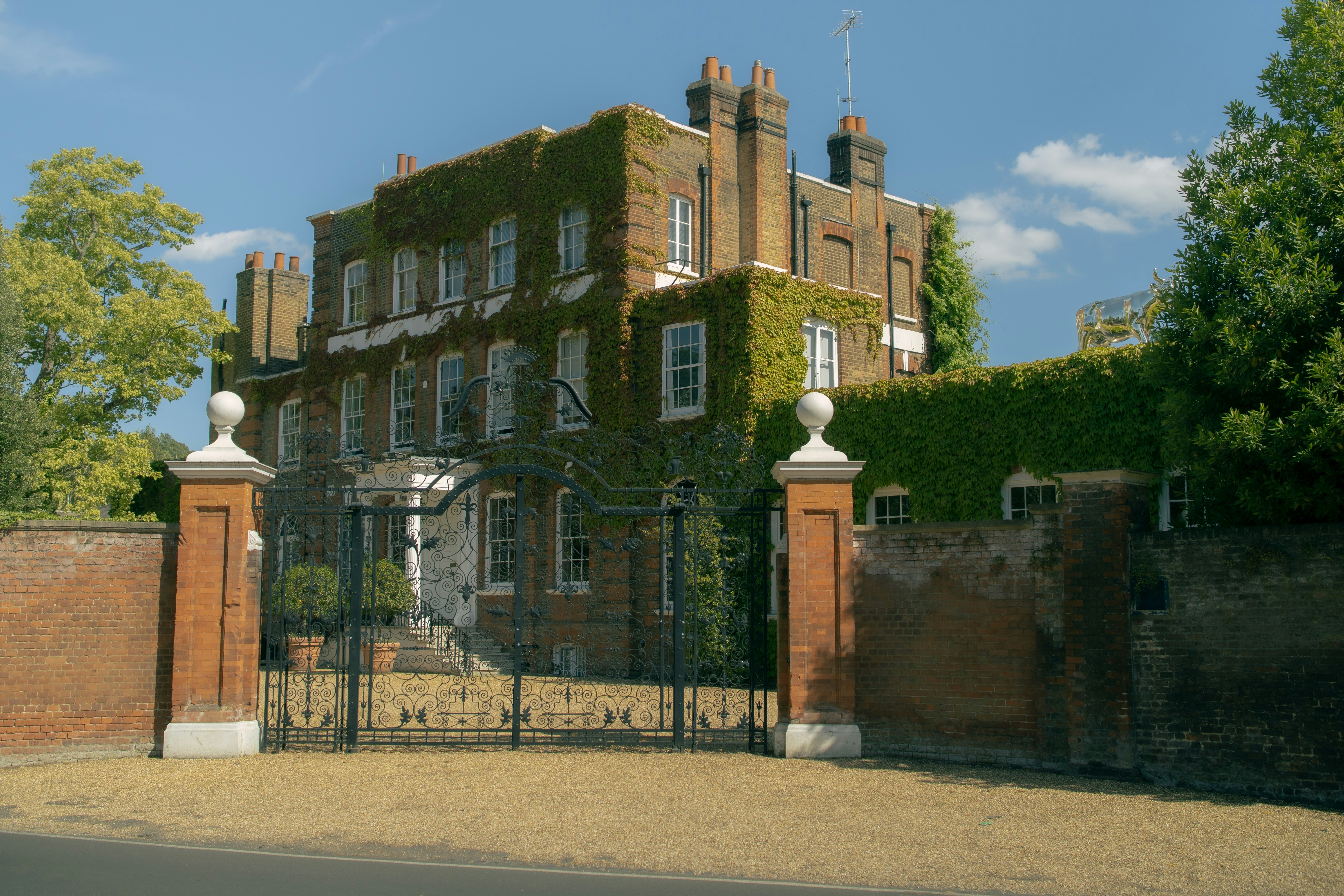 Ivy-clad manor behind an ornate gate