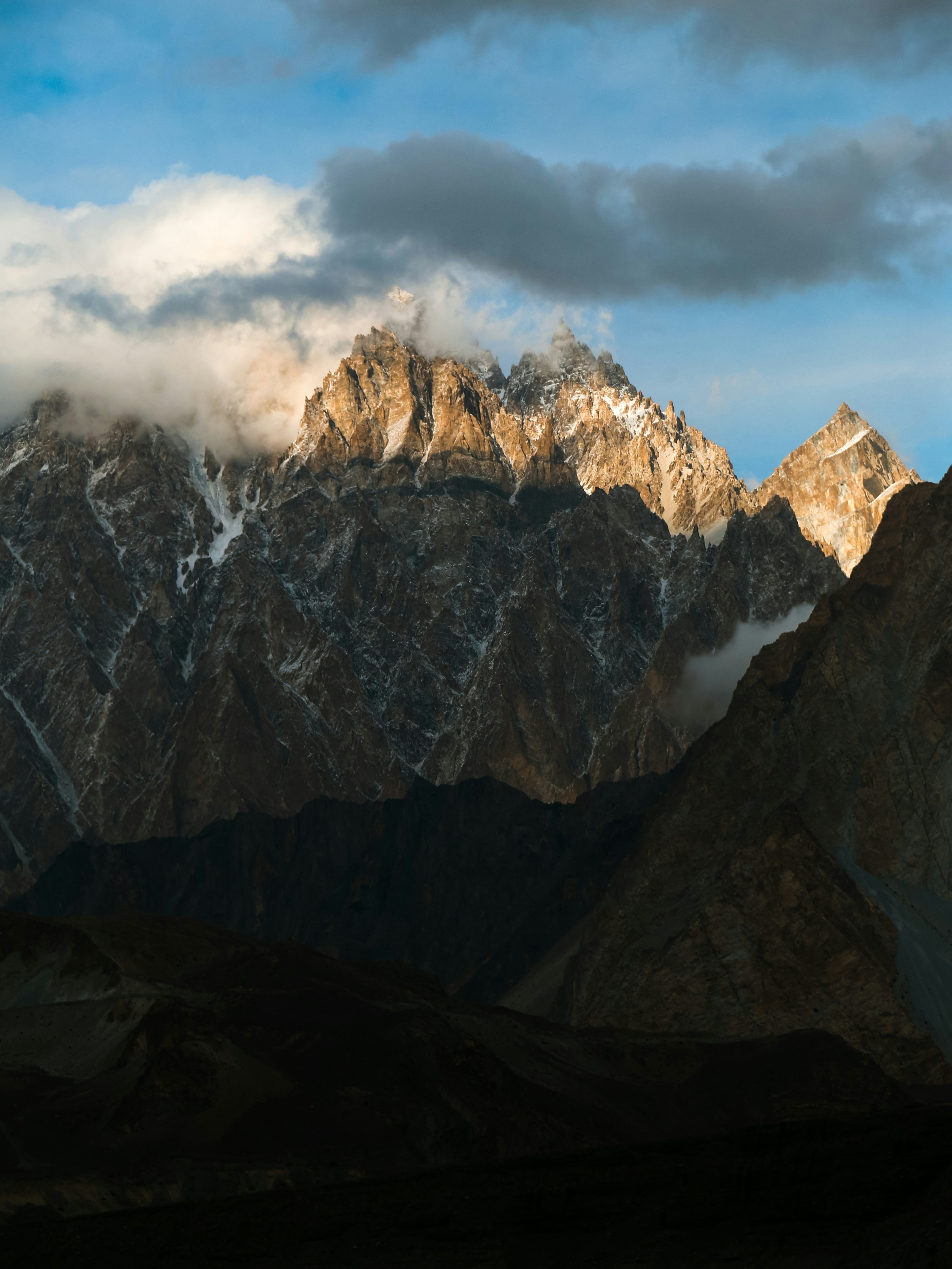 Crest of the Peaks: Sunlit Summit Amid Cloud Veils