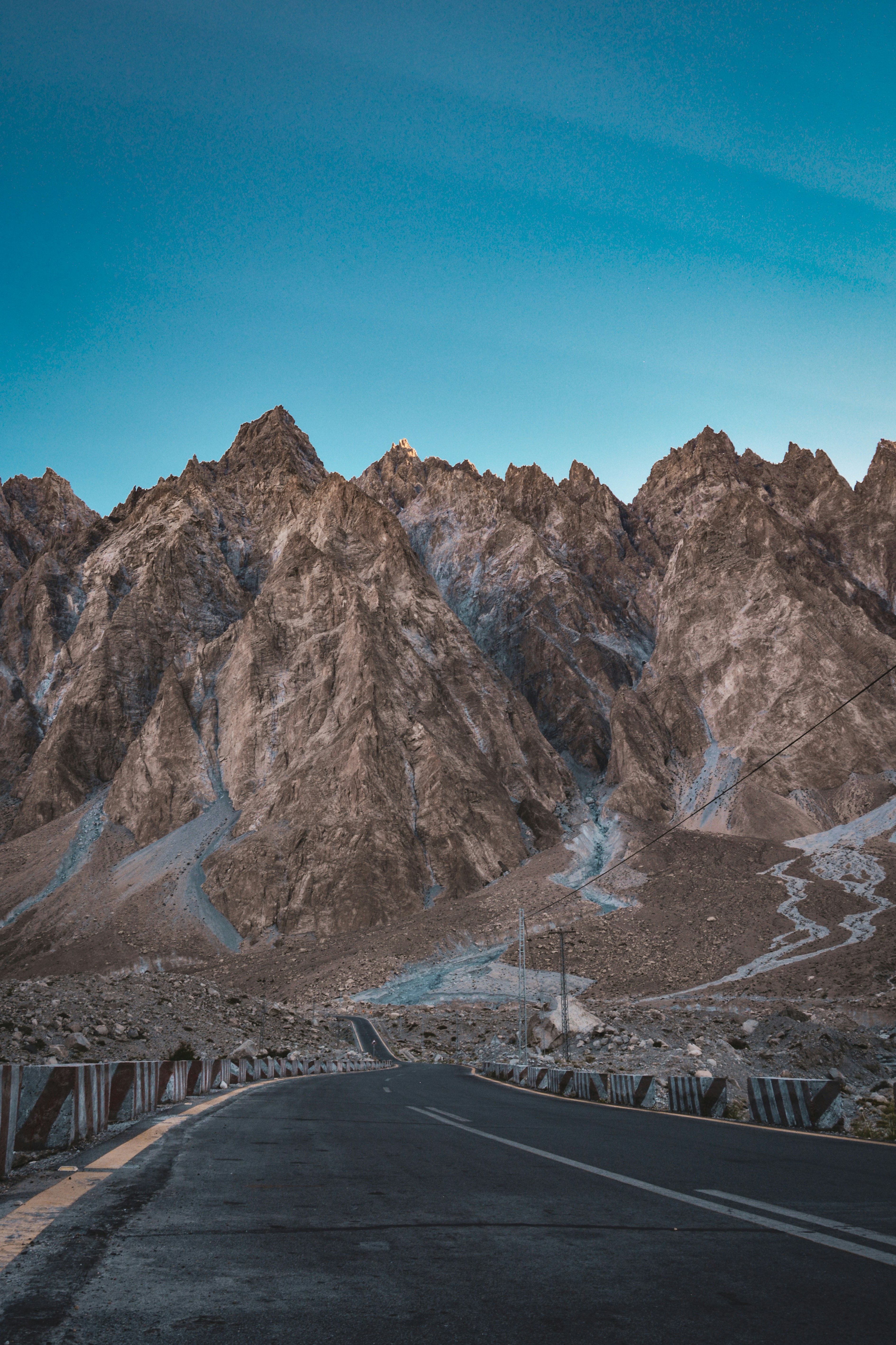 Road Toward the Rugged Spine: A Mountain Pass Under Clear Blue