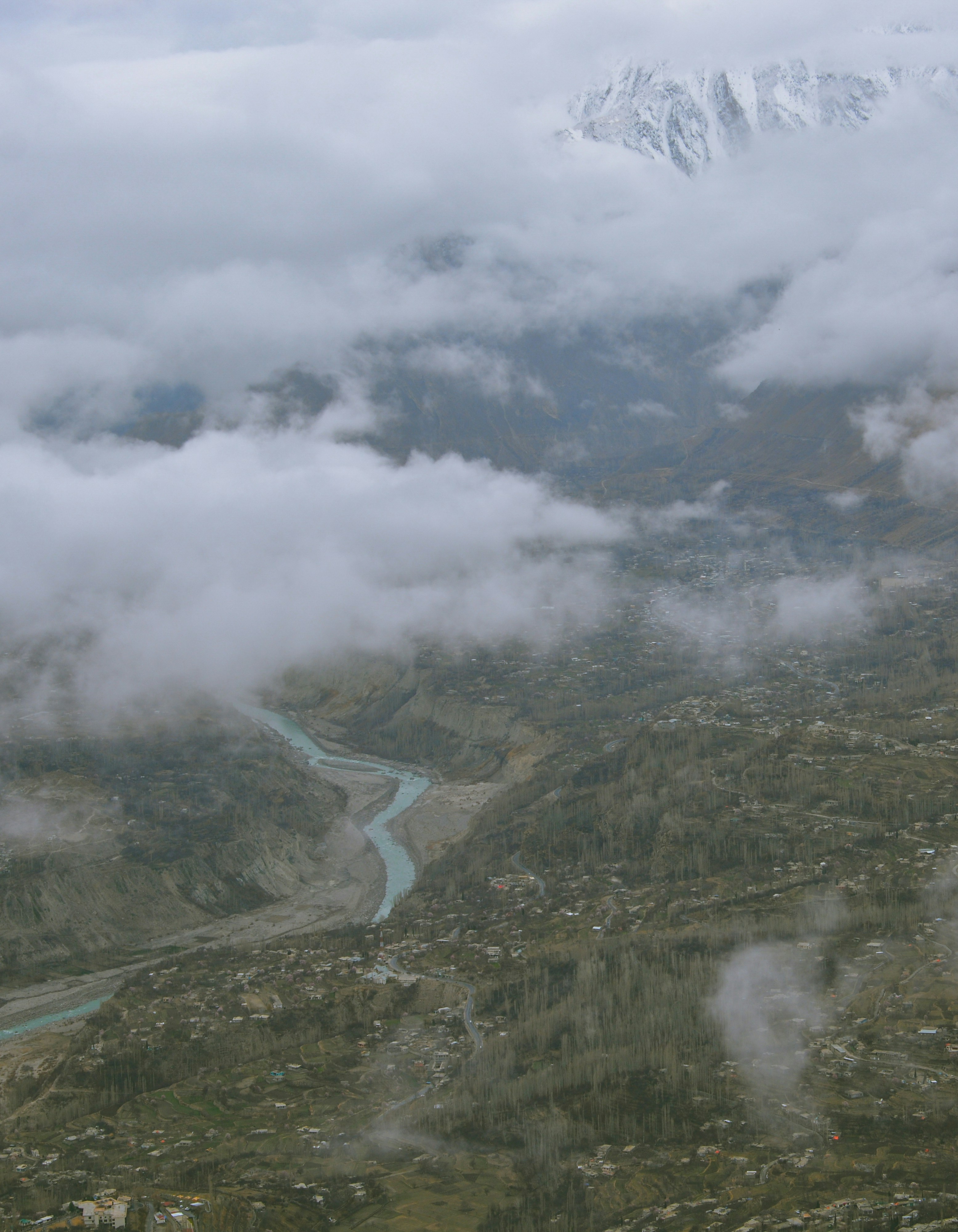 Valley Vein: A Snow-Capped Ridge Wading Through Clouds