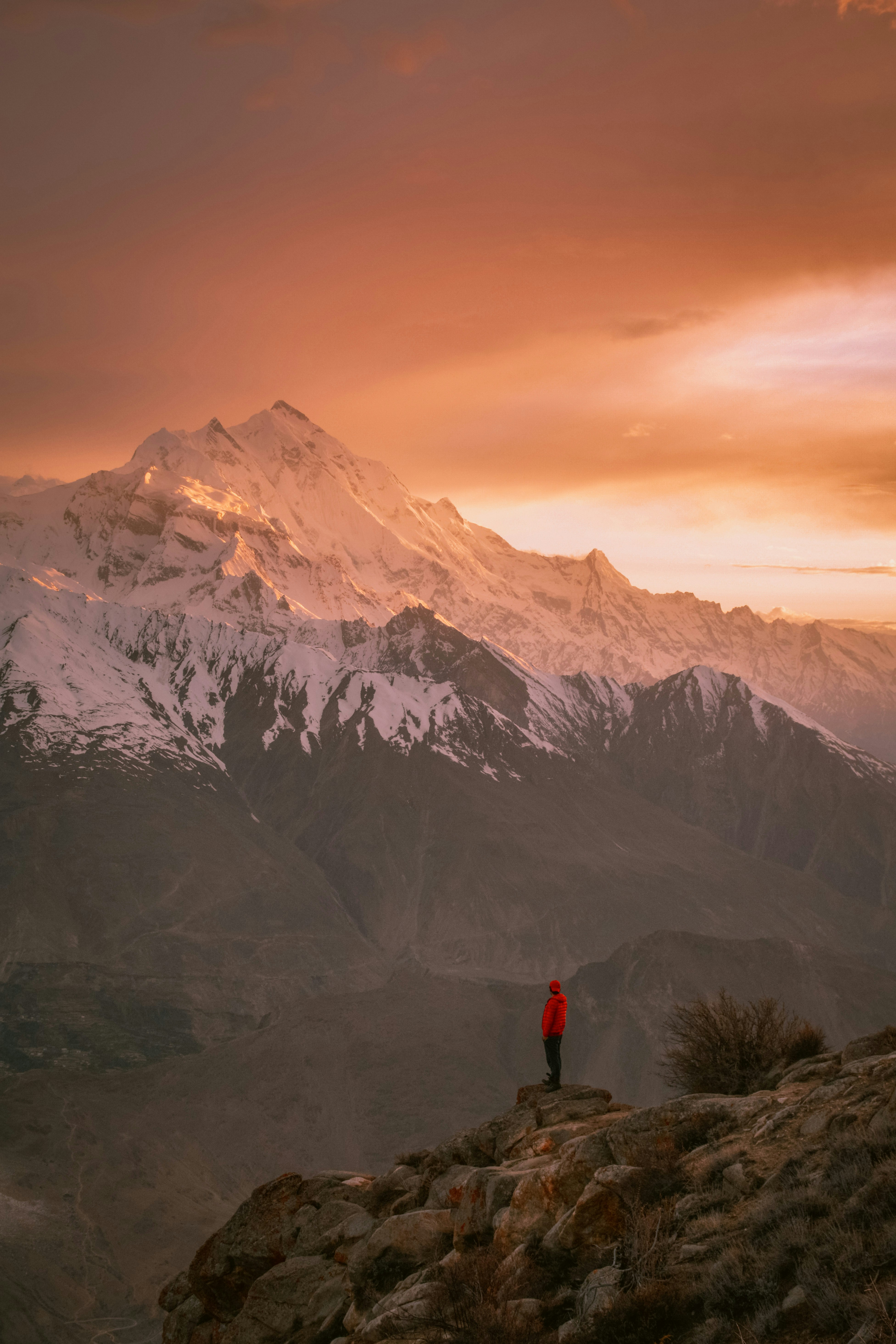 Red-clad Wanderer Beneath a Fiery Alpine Crest