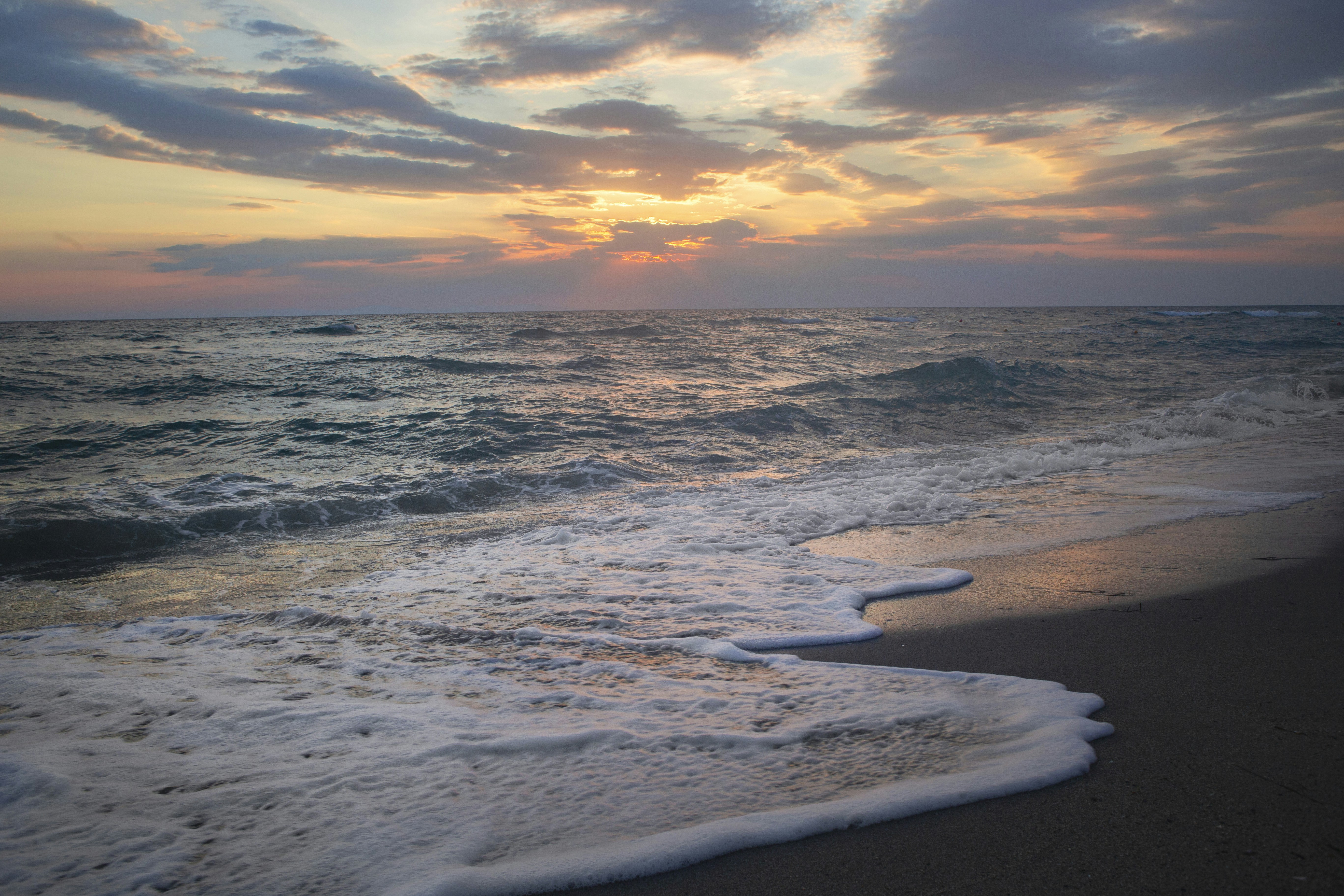 Sunlit Crest: Foamy Waves Greet the Dusk
