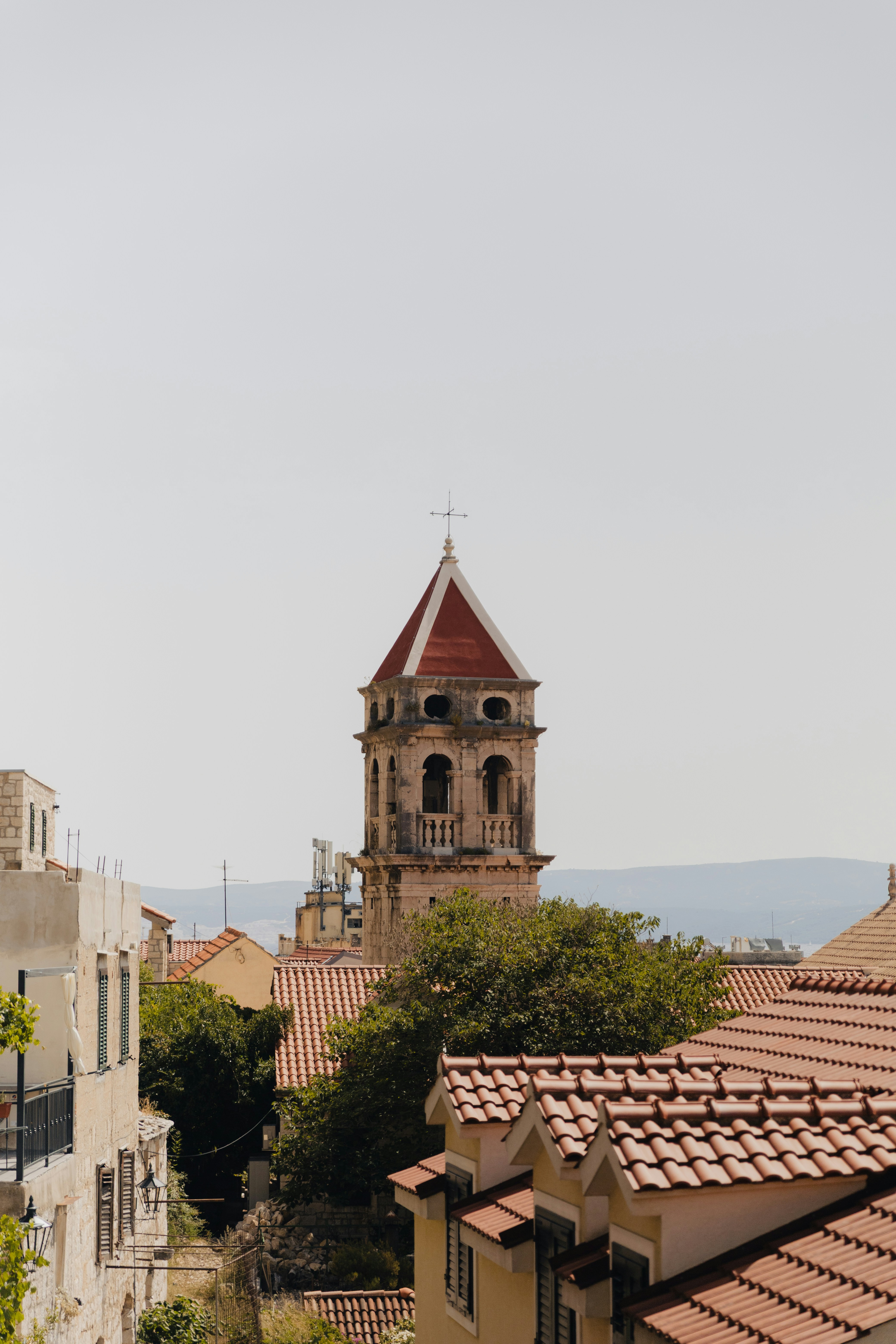 Bell Tower Rising Above Red-Tiled Skyline