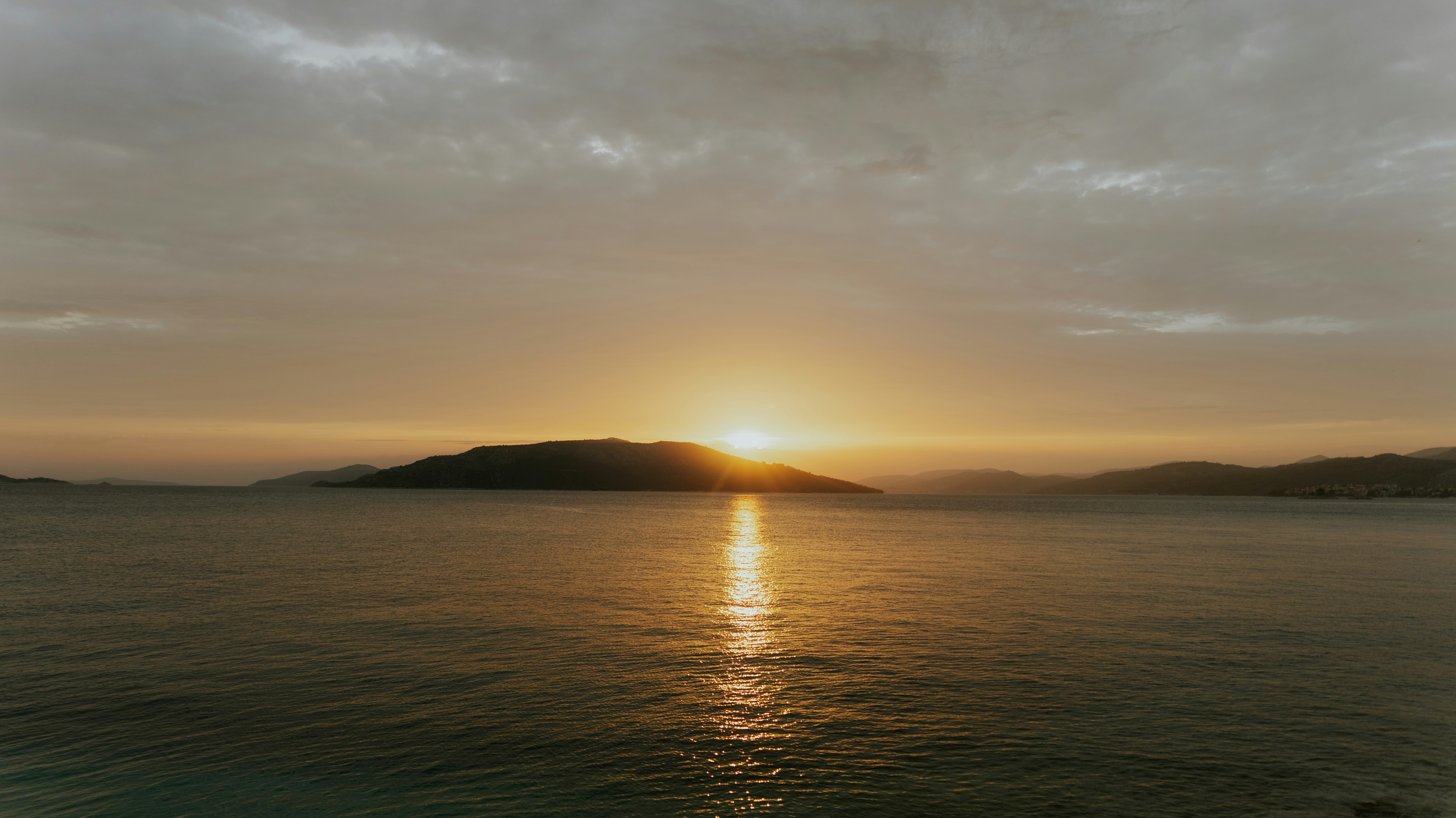 Dawn Kissed Island: Sunlit Horizon Across Calm Seas
