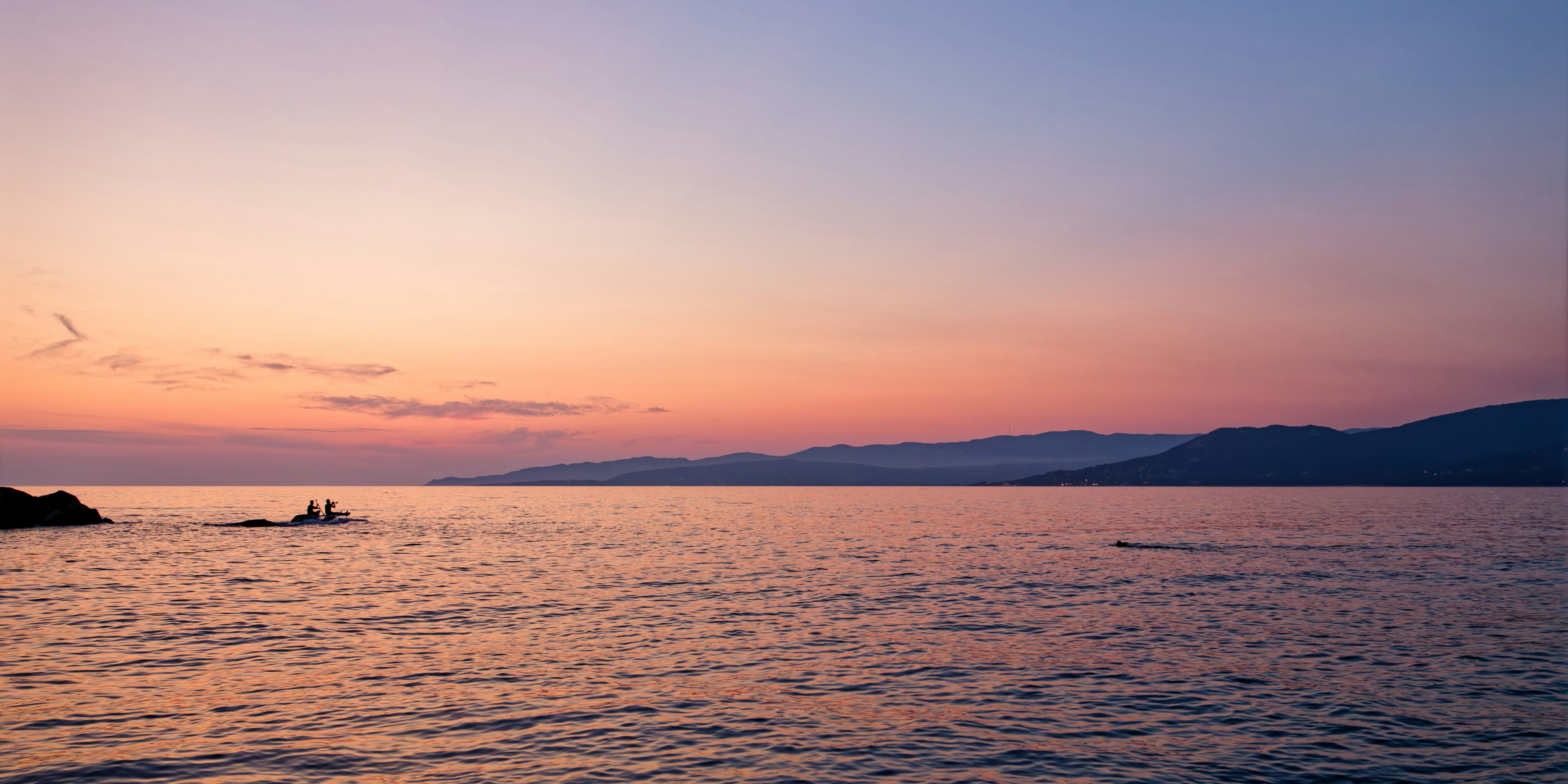 Dusk over calm sea: gentle gradients and distant silhouettes