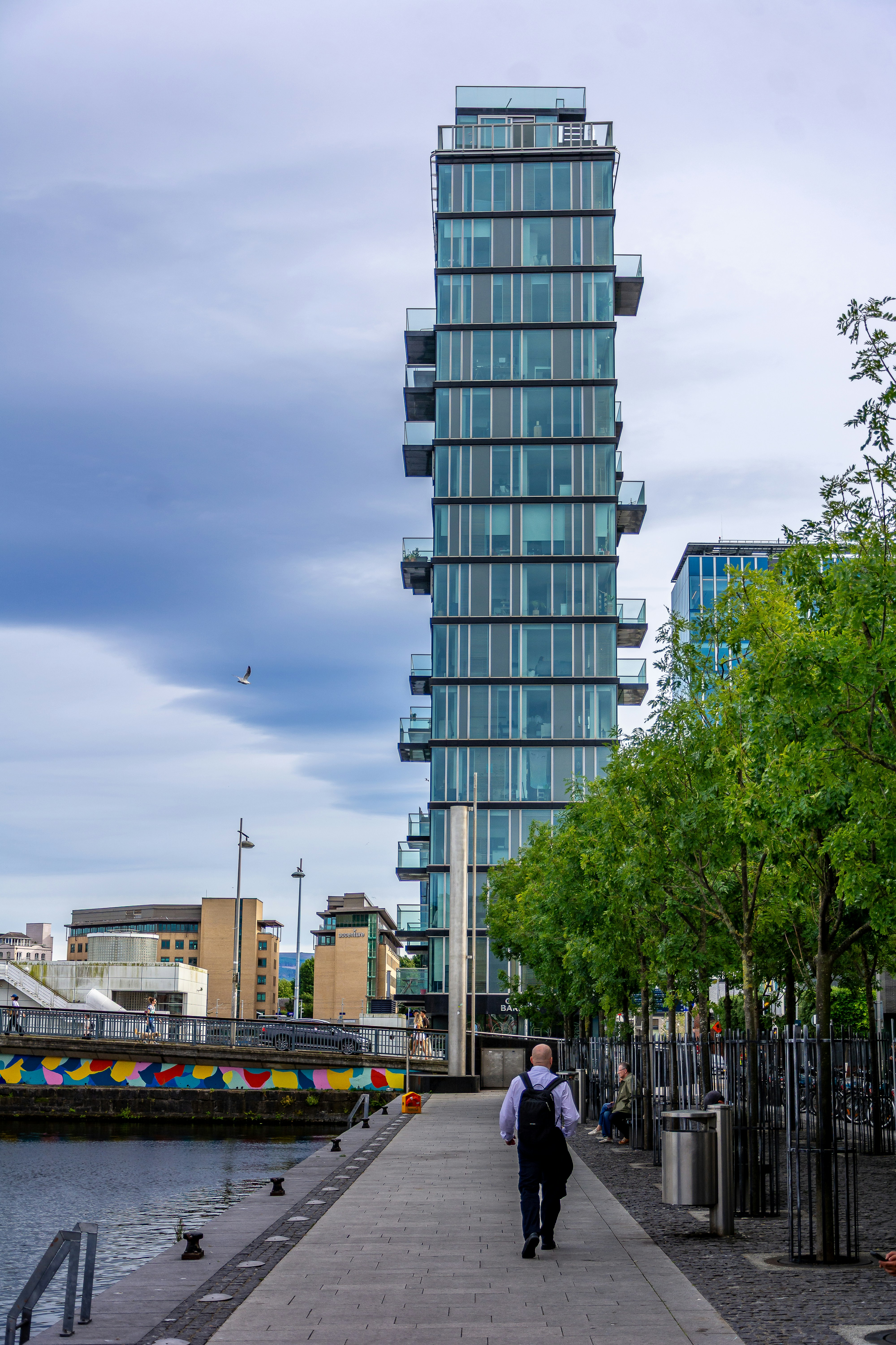 Towering Glass: The Riverfront Walkway Bows to a Skyward Spine