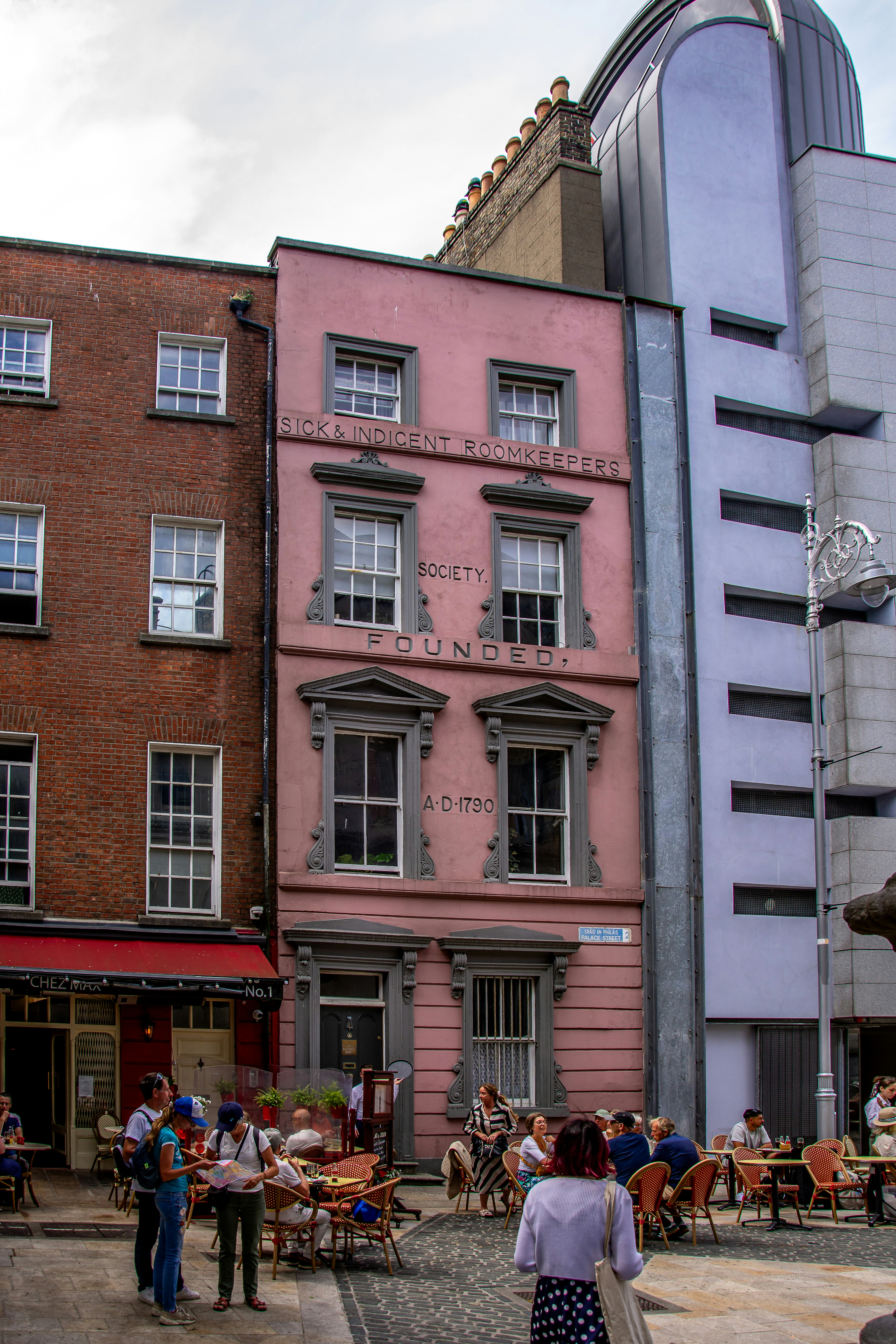 Pastel Facade Rendezvous: Café Life Along Cobbled Street