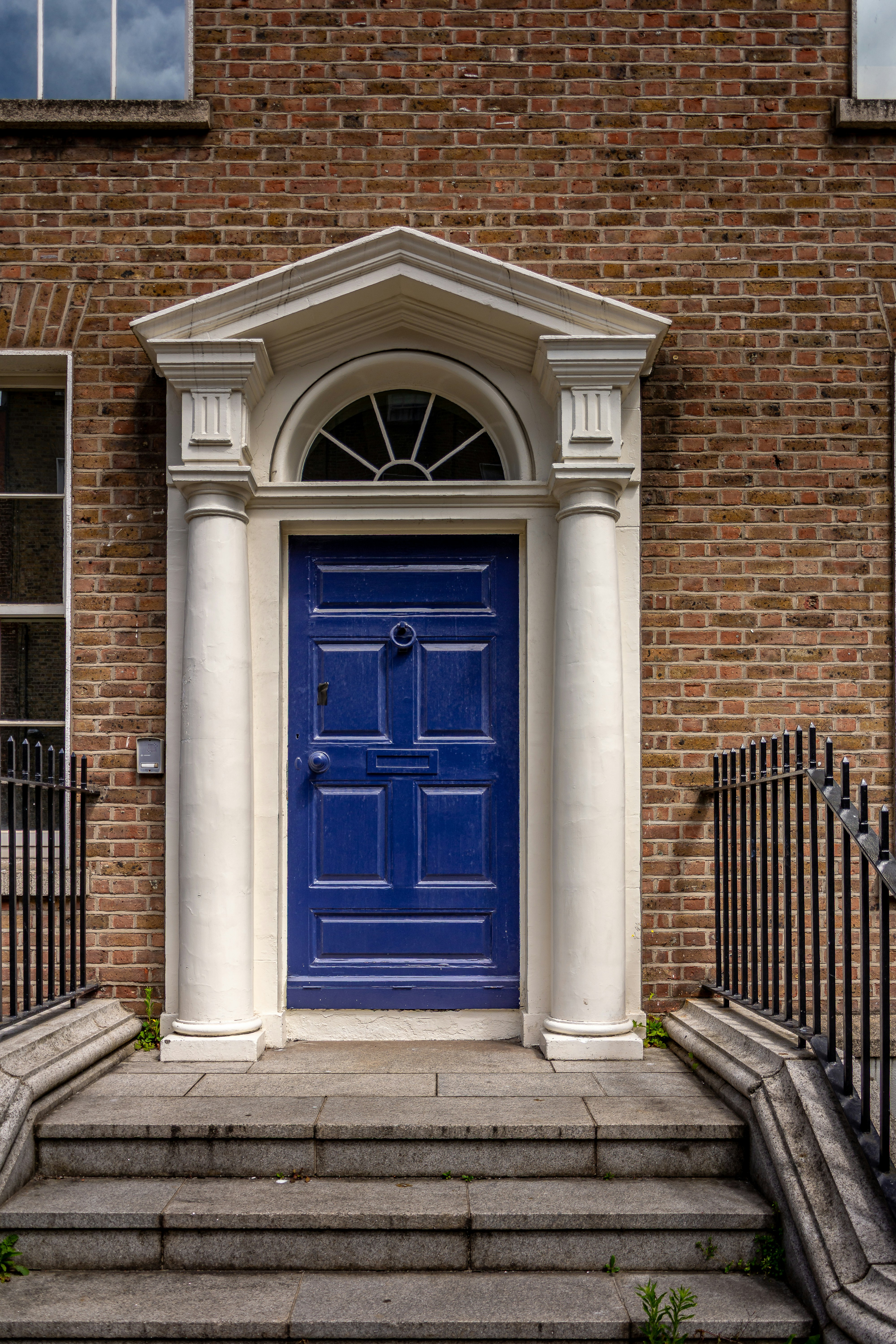 Blue Doorway on Brick Facade: Classical Entrance with Elegant Portico