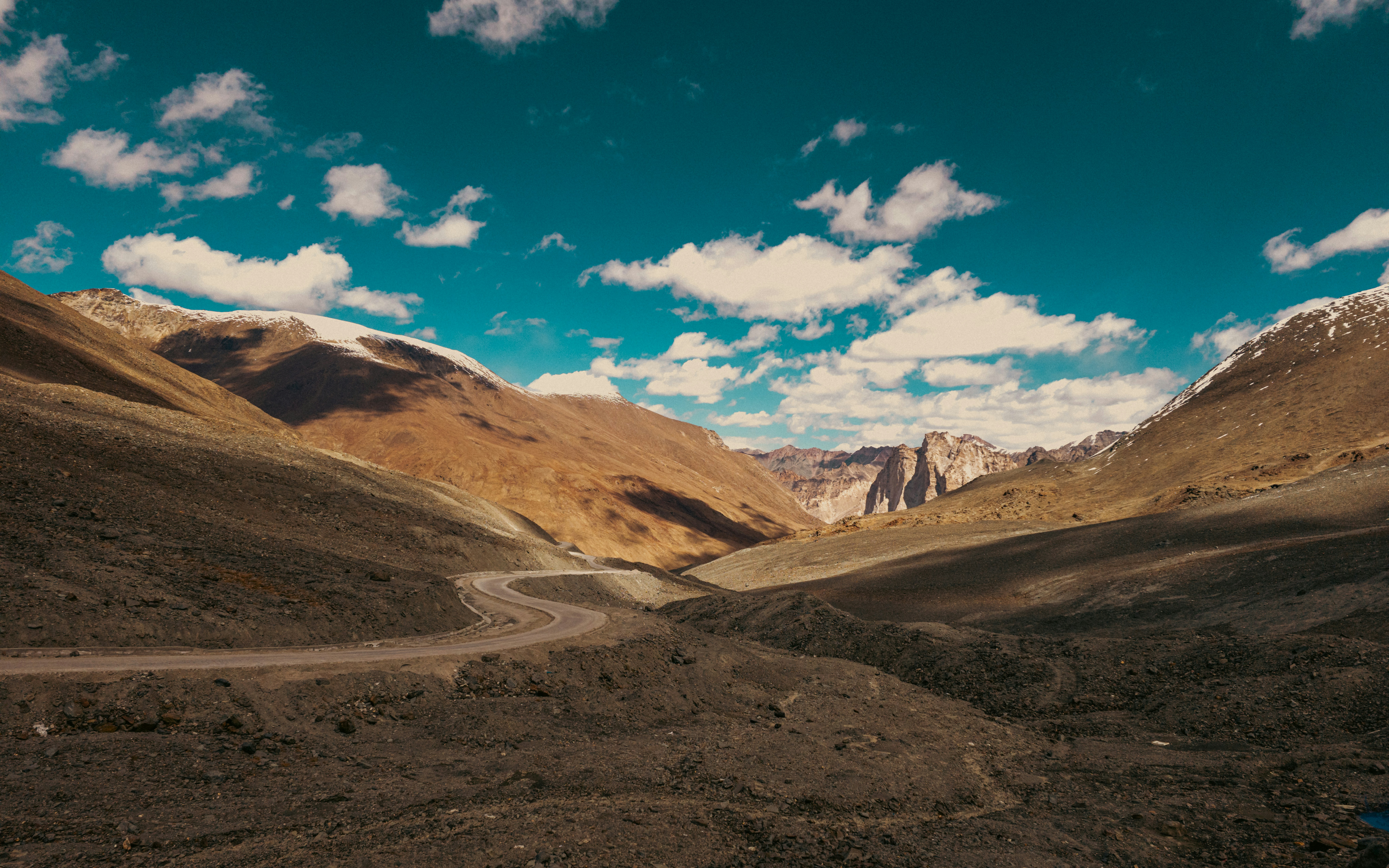 Desert Ribbon: A Winding Road Through Dolomitic Hills Under a Cerulean Sky