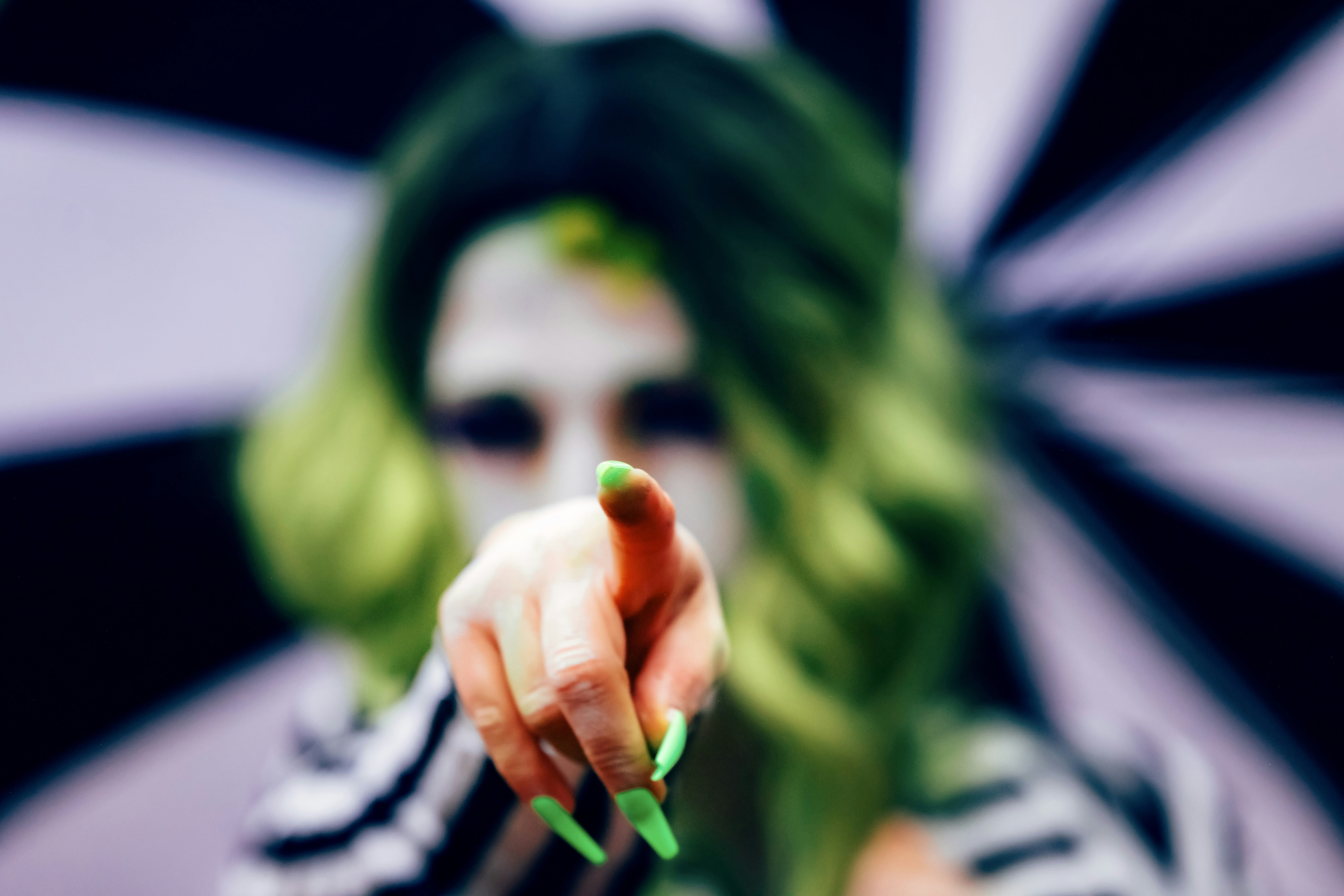 Pointing Through Neon Nails: A Blurred Portrait with a Central Gesture
