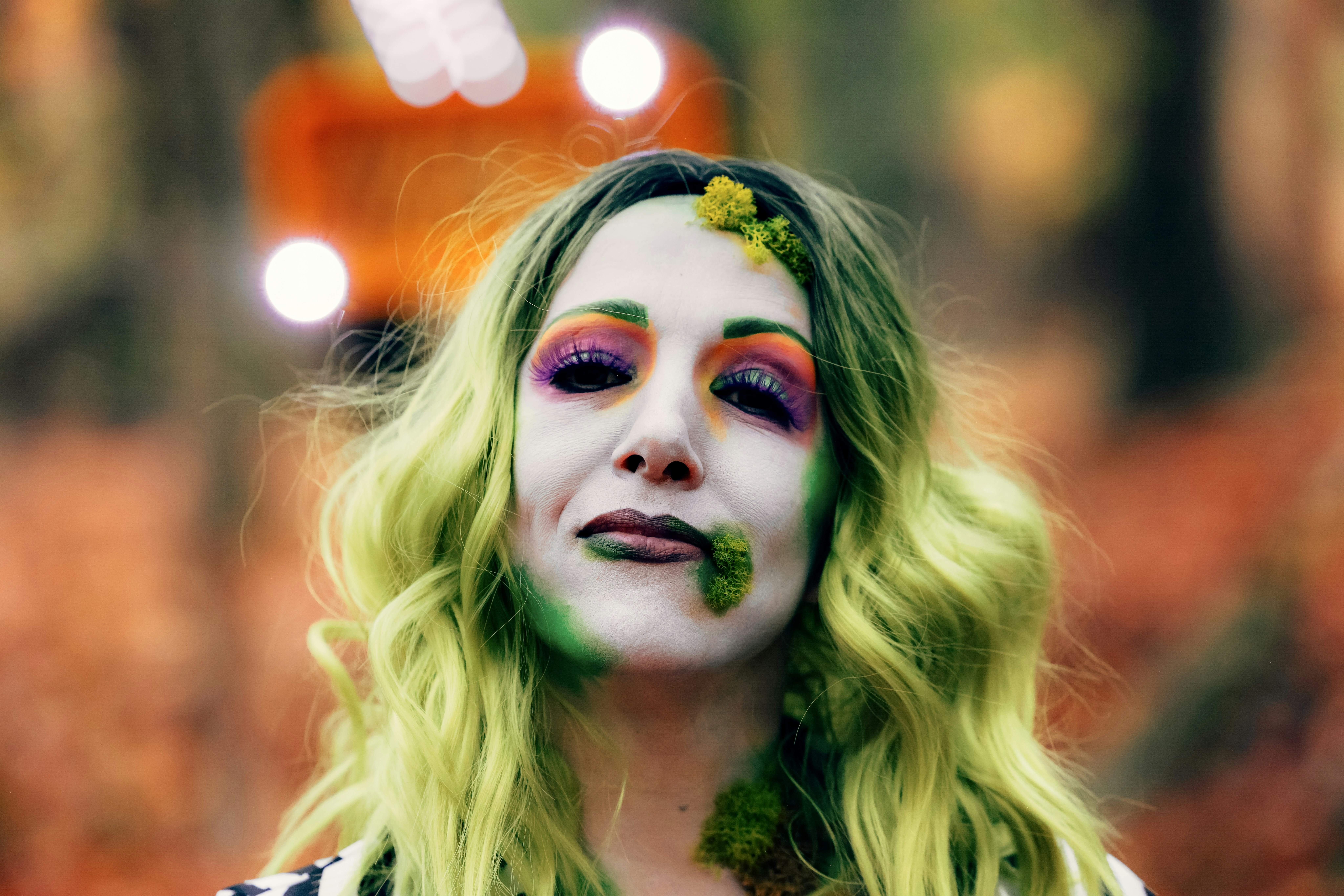 Emerald-tinged portrait with daubed makeup and autumn glow