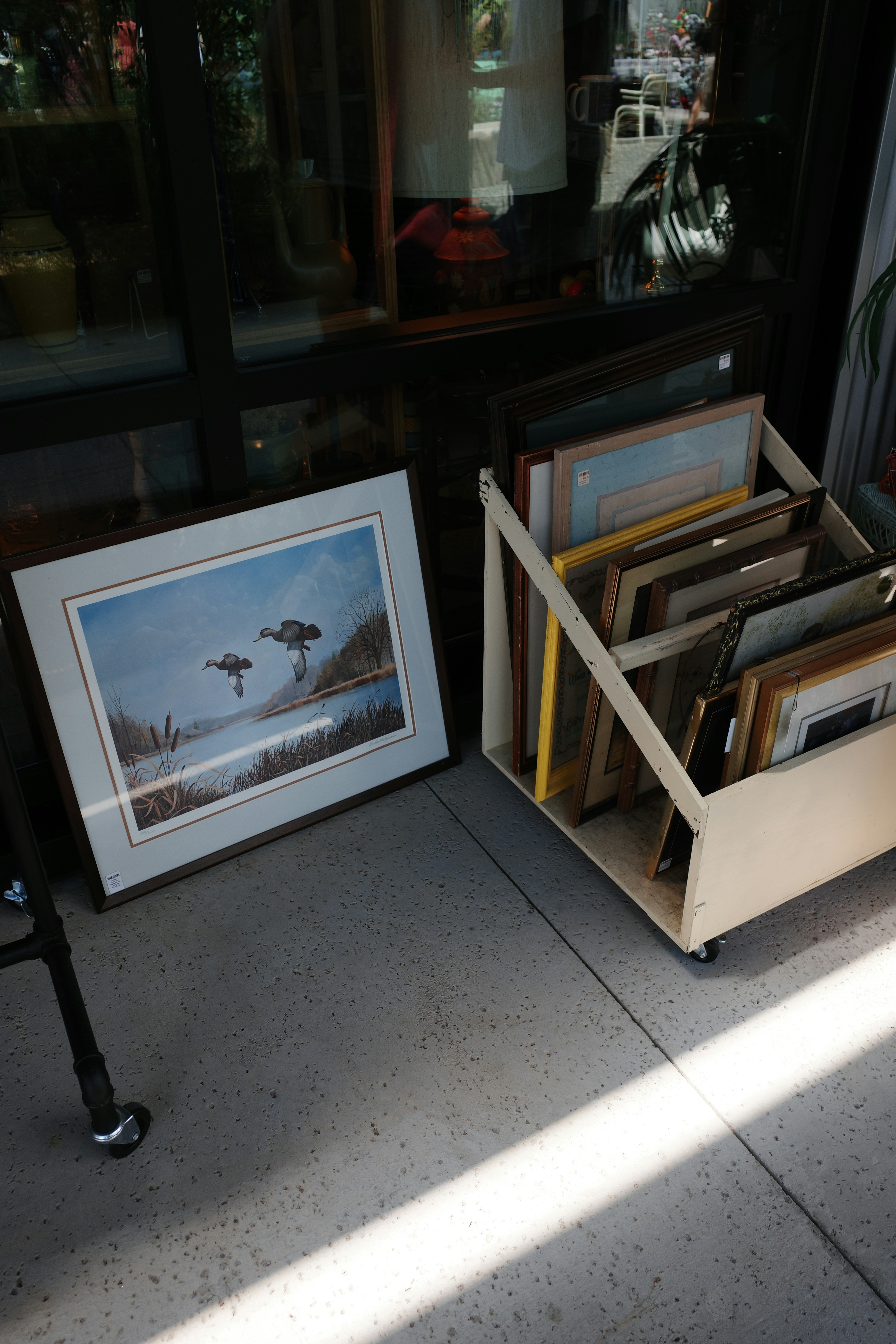 Framed memories on display: a cropping of art crates outside a shop