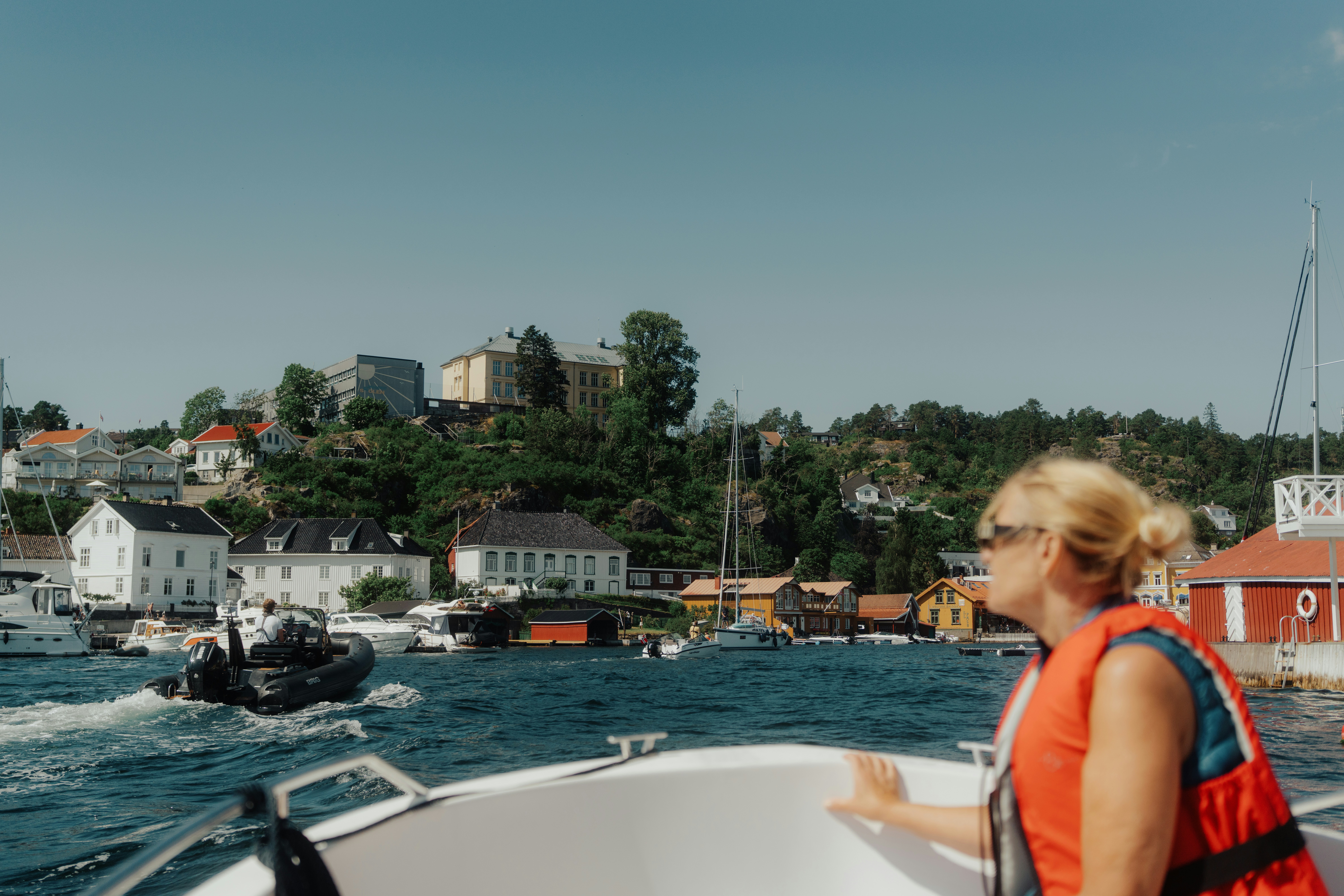 Rough waters and harbor bustle: a speedboat moment with a foreground traveler