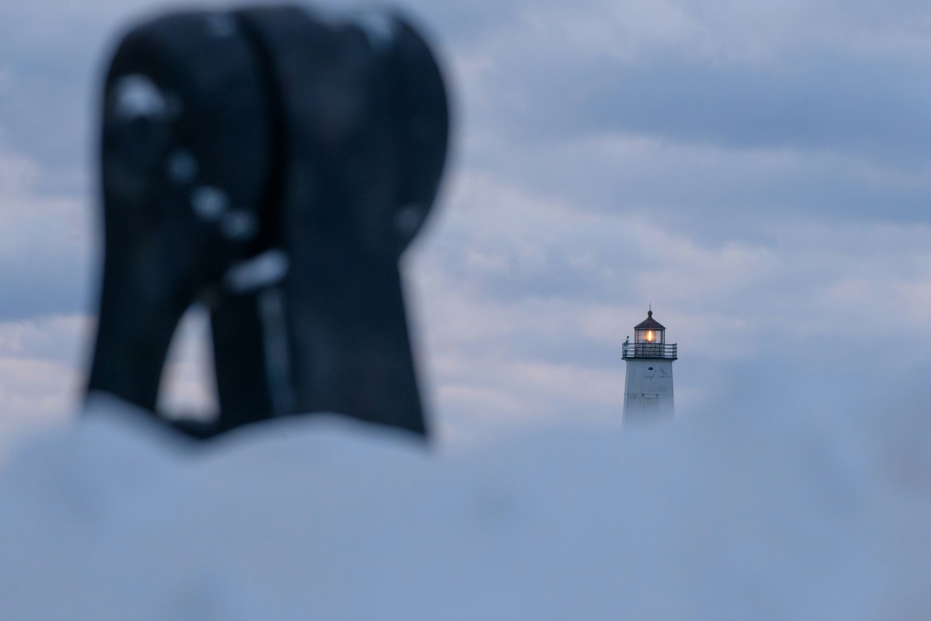 Lighthouse in Focus: A distant beacon through a wintry veil
