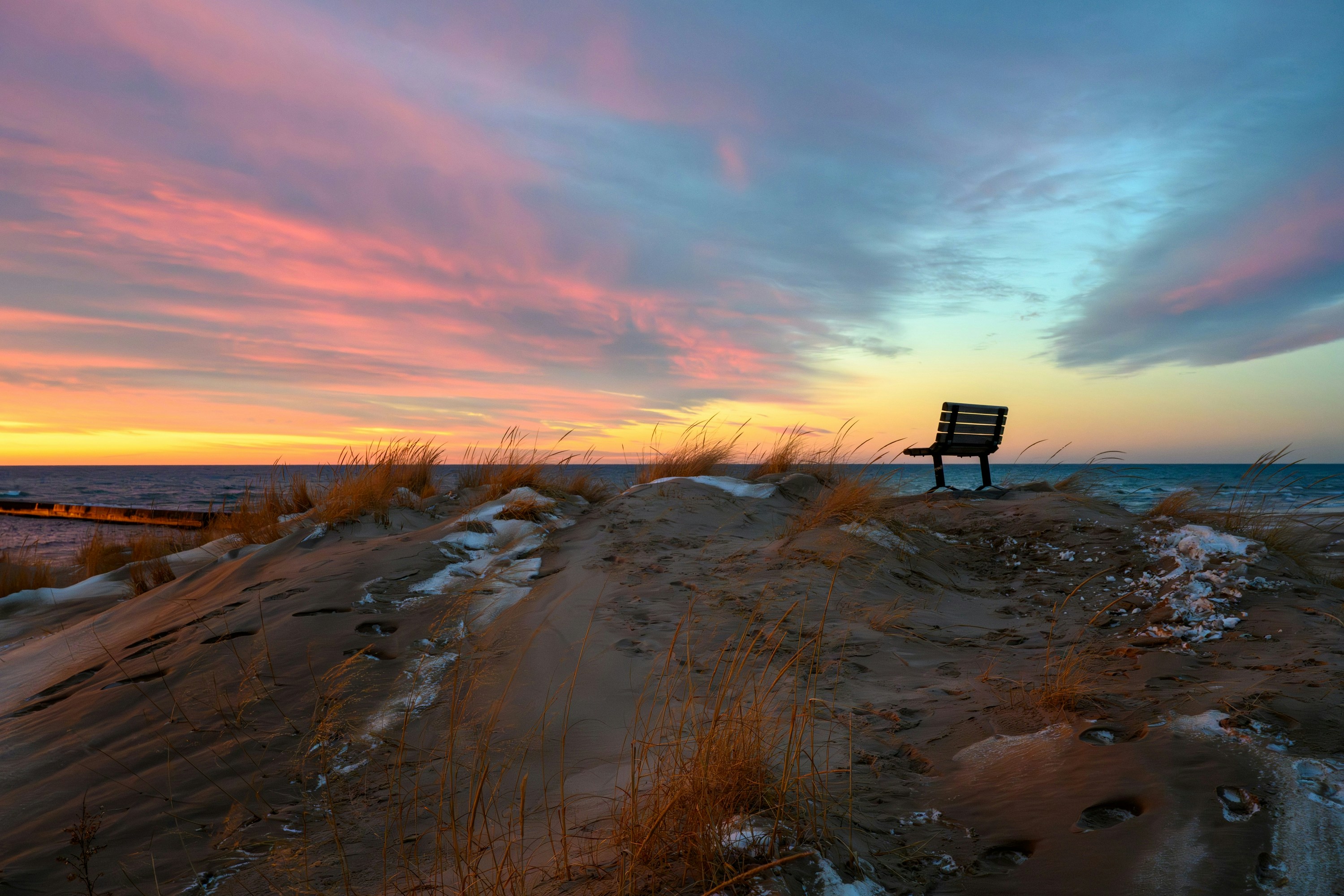 Dune Bench at Sunset: Quiet Horizon and Wind-Swept Grass