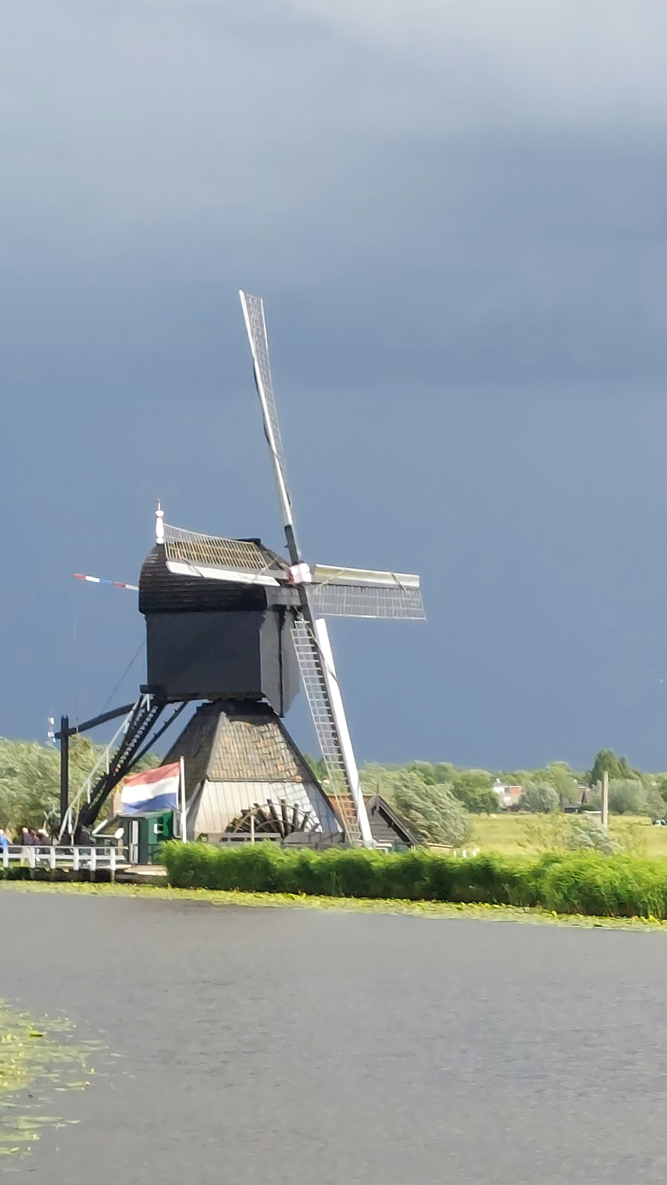 Windmill Sentinel by the River: Dutch Heritage at Dusk