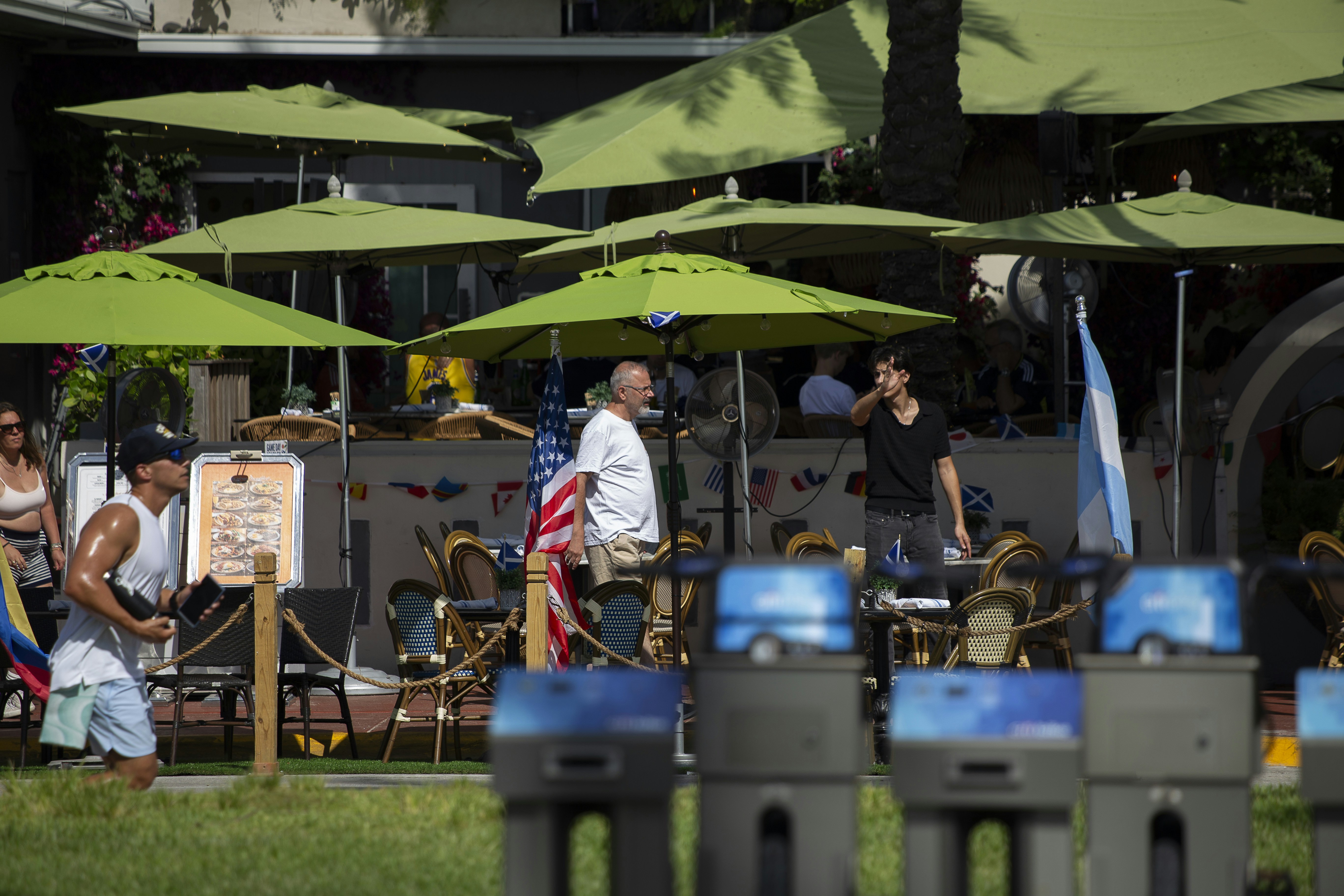 Sunny Patio Humans: A Moment Under Green Parasols at the Cafe
