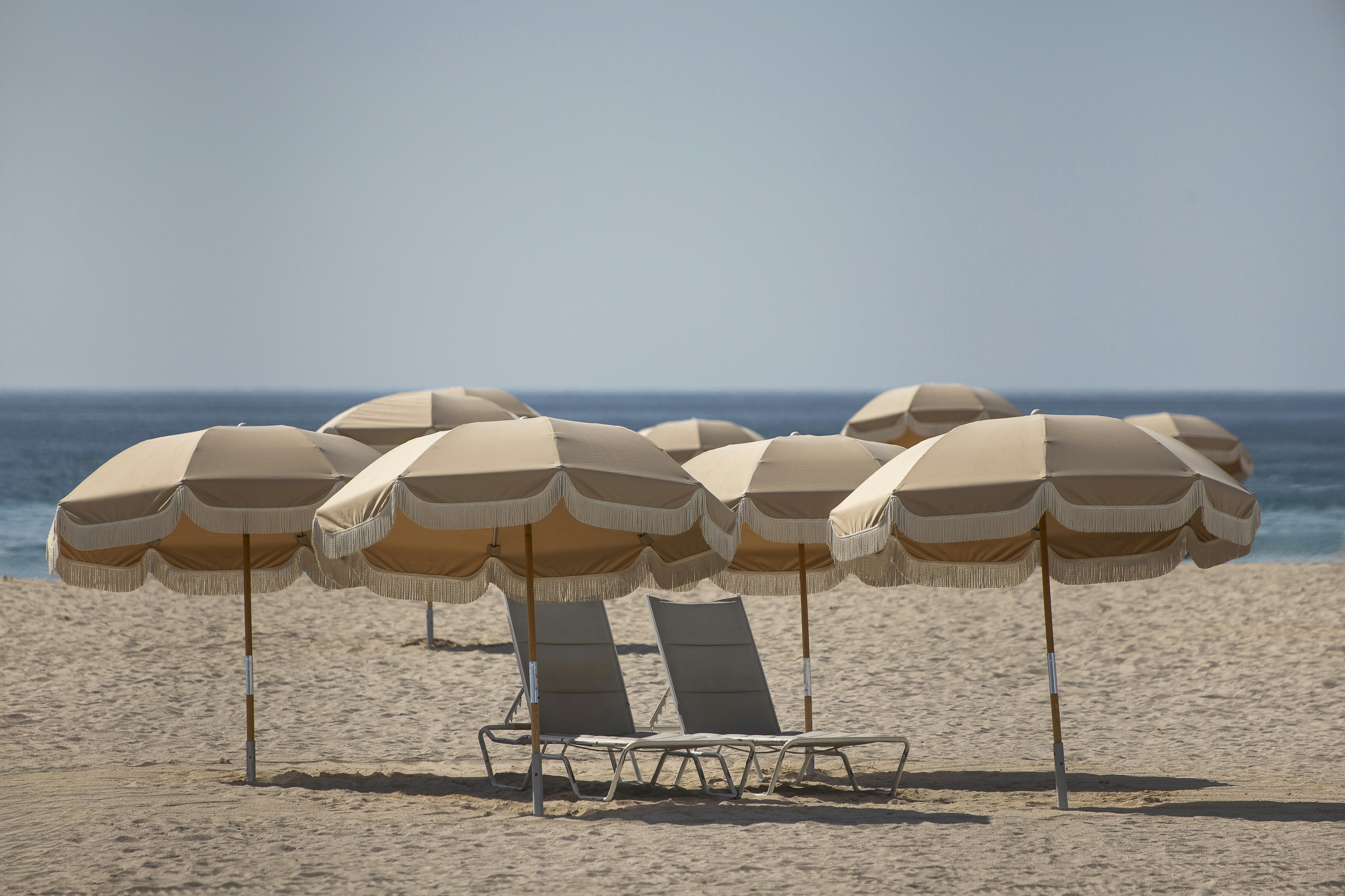 Rows of Quiet Shade: Umbrellas and Lounge Chairs on a Sunlit Beach