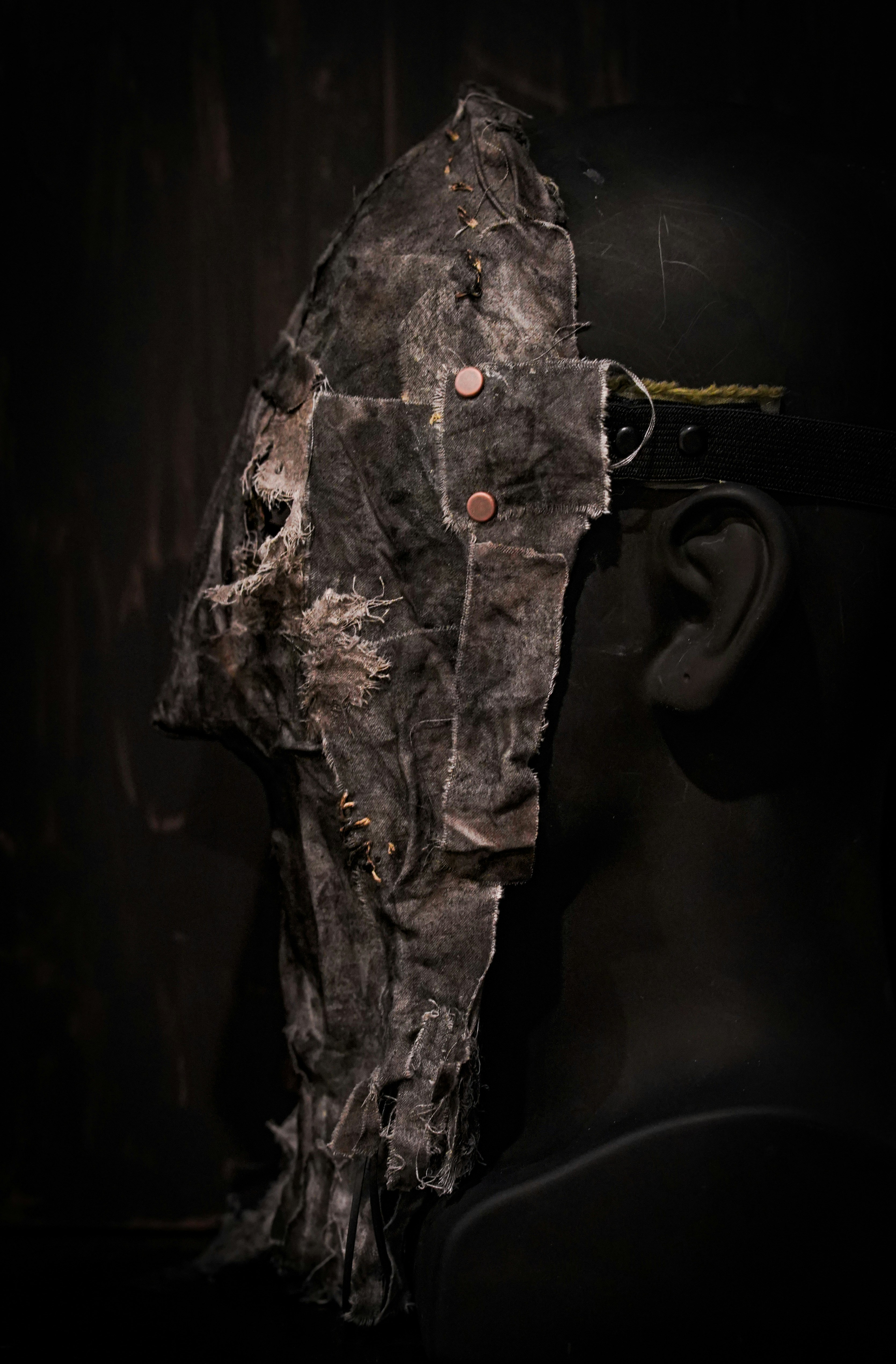 Tattered Mask of Silence: A Dark Handcrafted Headpiece in Dim Light
