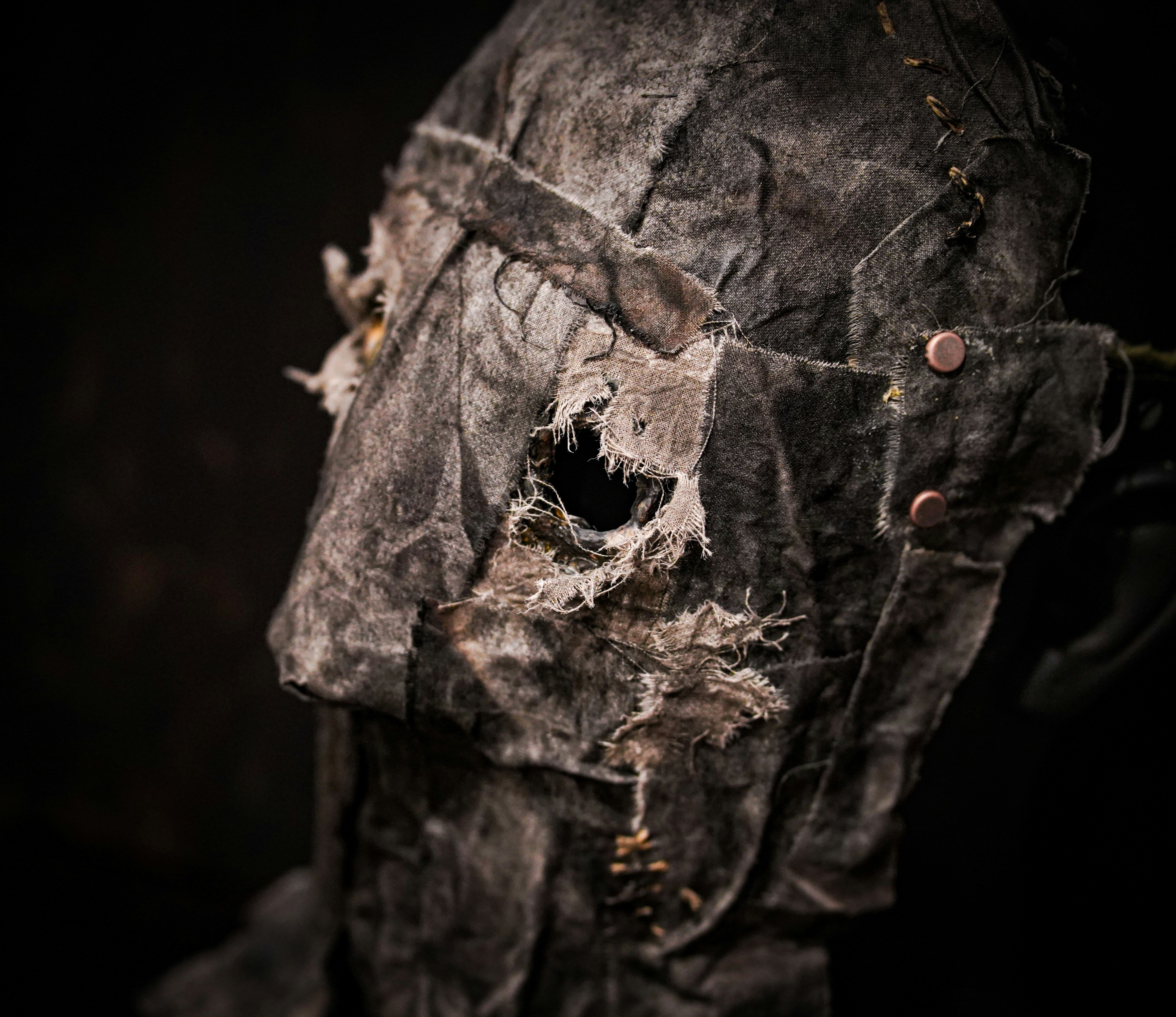 Tattered Shroud: Weathered Fabric Mask in Shadowed Veil