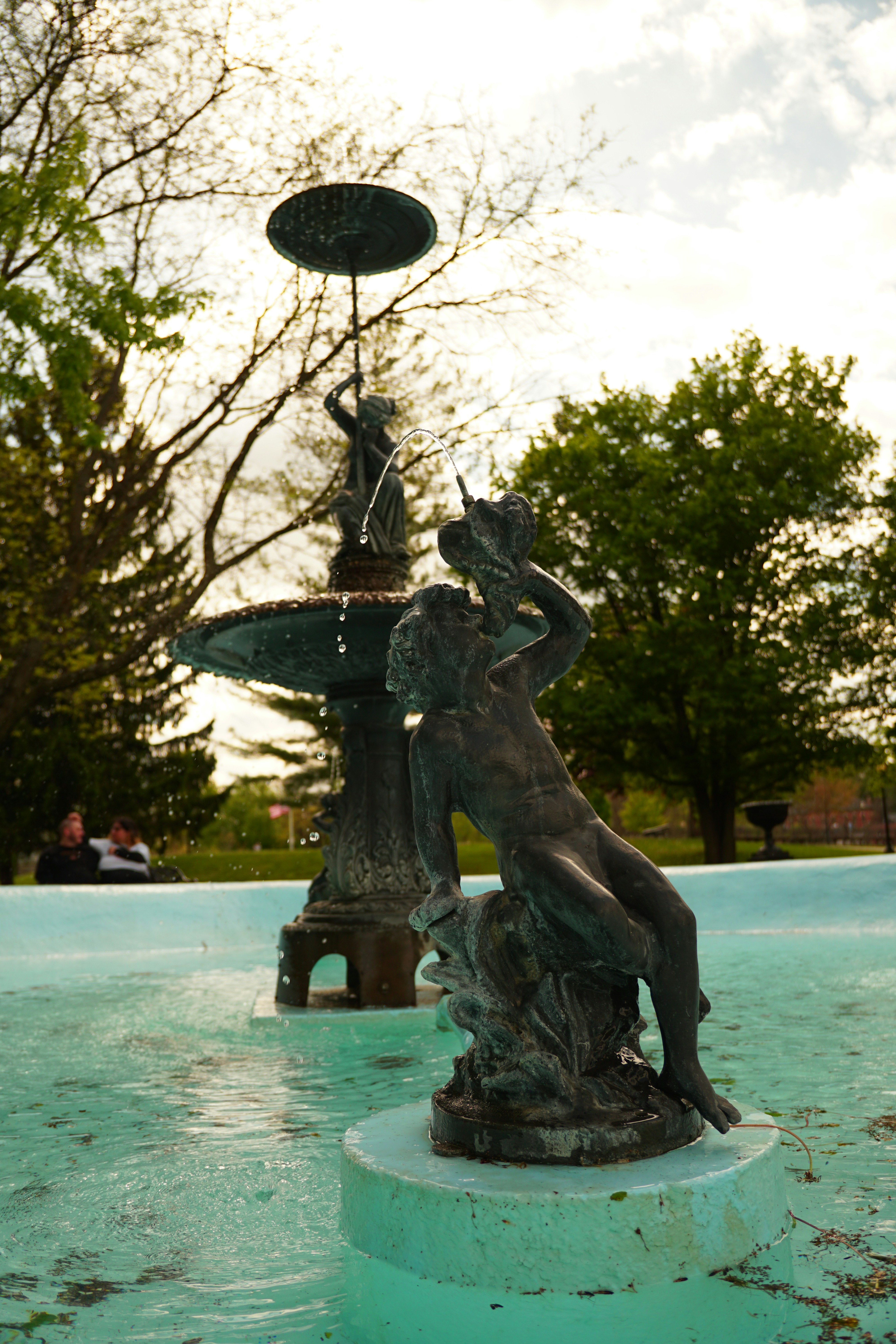 Bronze Spray: A Fountain Figure Reaches Toward the Sky