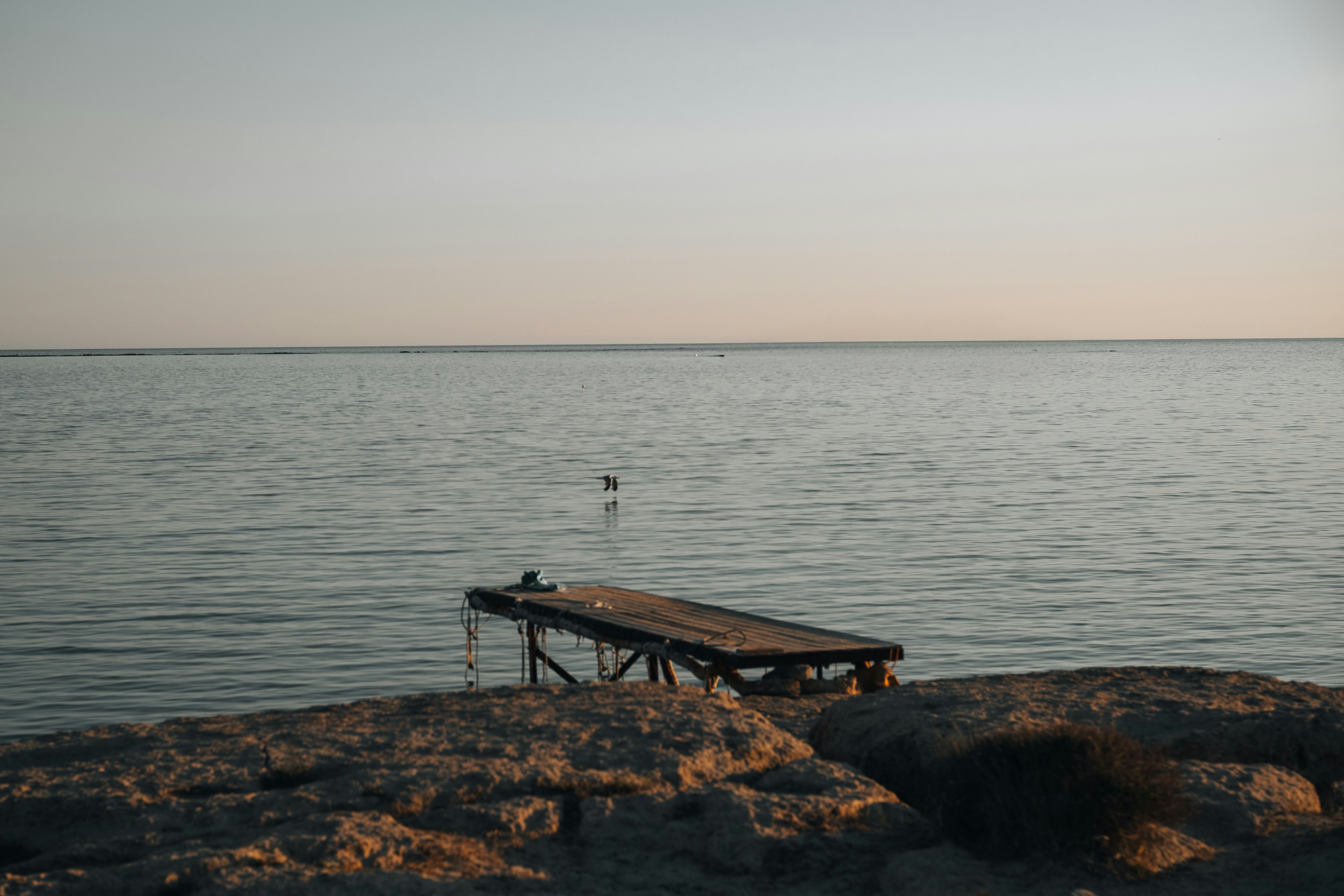 Quiet Jetty at Dusk: A Rusted Pier Reaches Toward a Calm Horizon